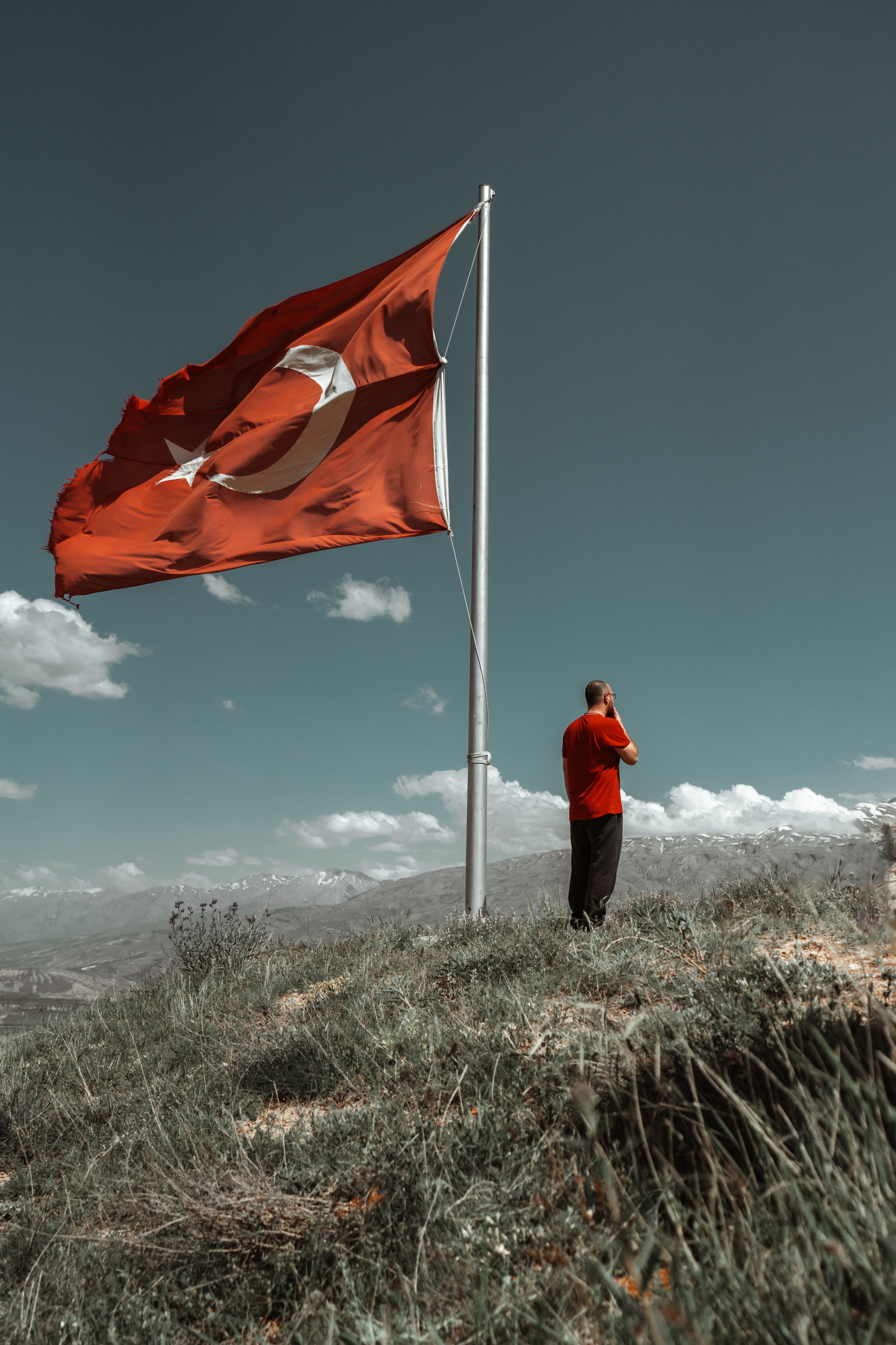 Man Standing near Turkish Flag on Hill · Free Stock Photo