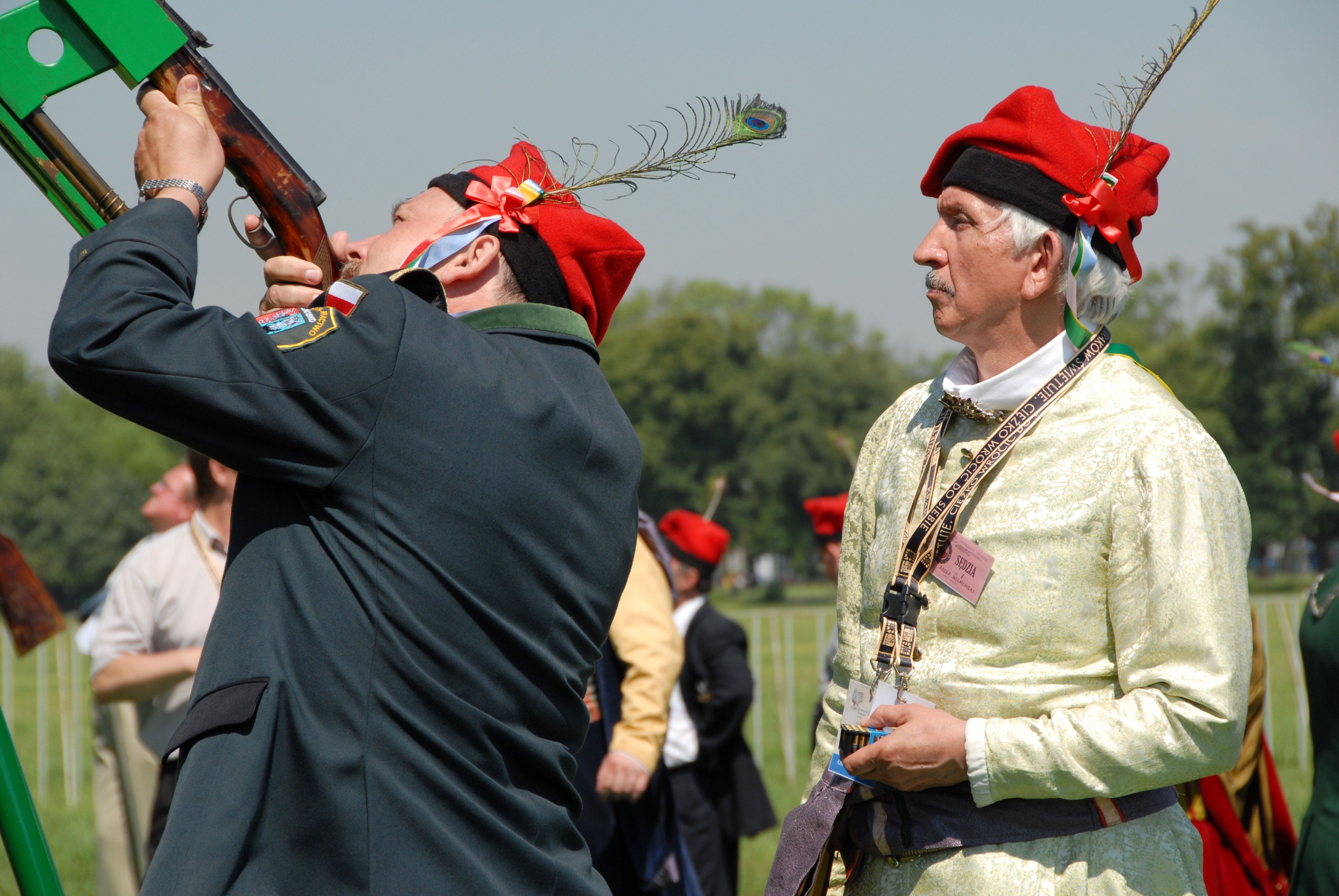 Men in Traditional Red Hats with Peacock Feathers Participating in ...