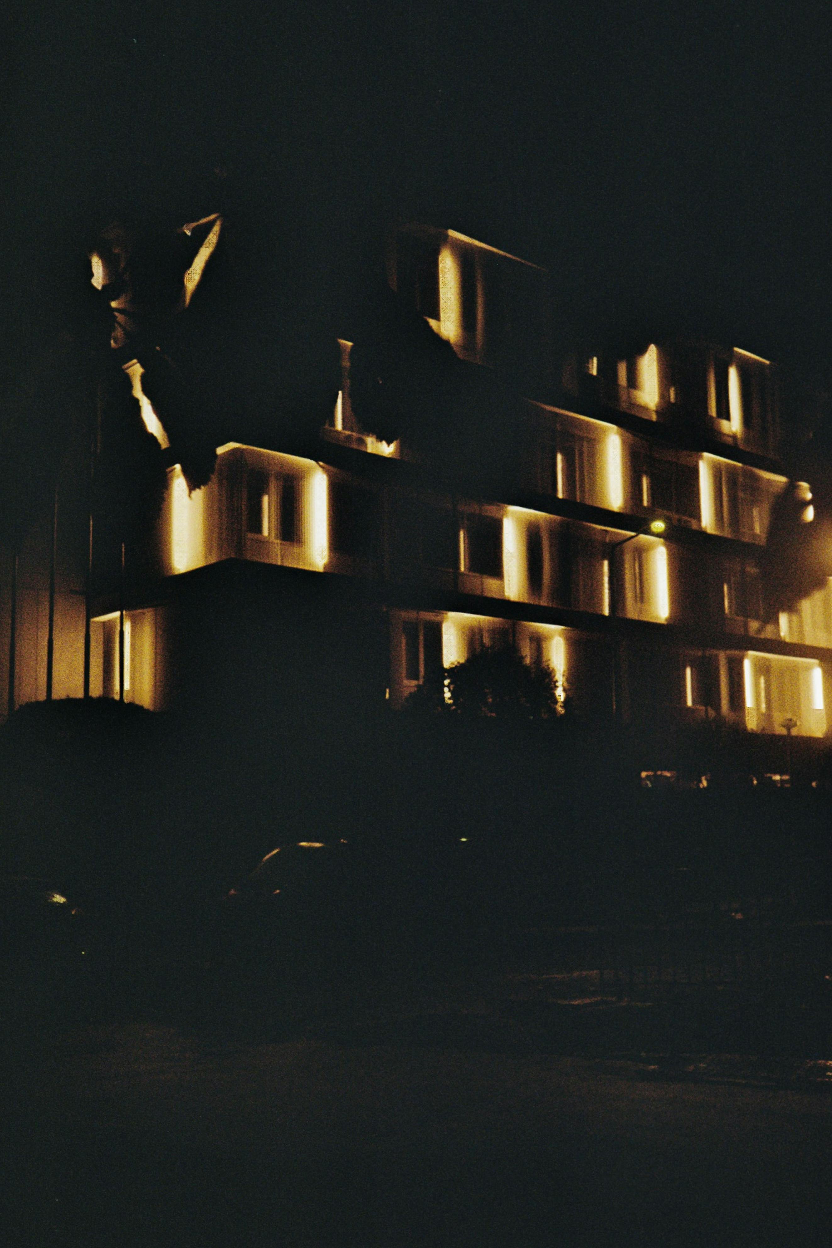 A building with lights on at night · Free Stock Photo