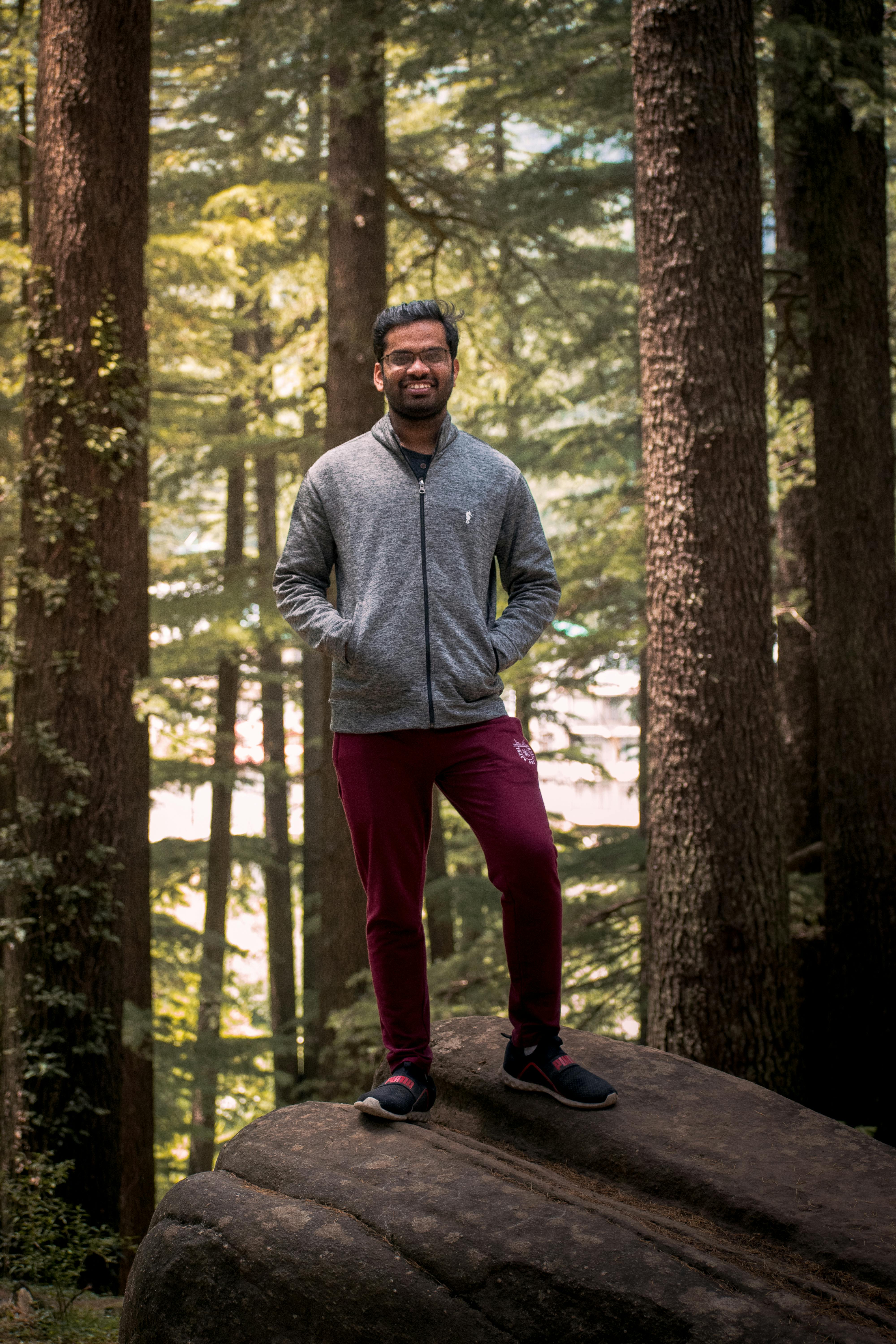 Man in Tracksuit Standing on a Rock in the Forest · Free Stock Photo