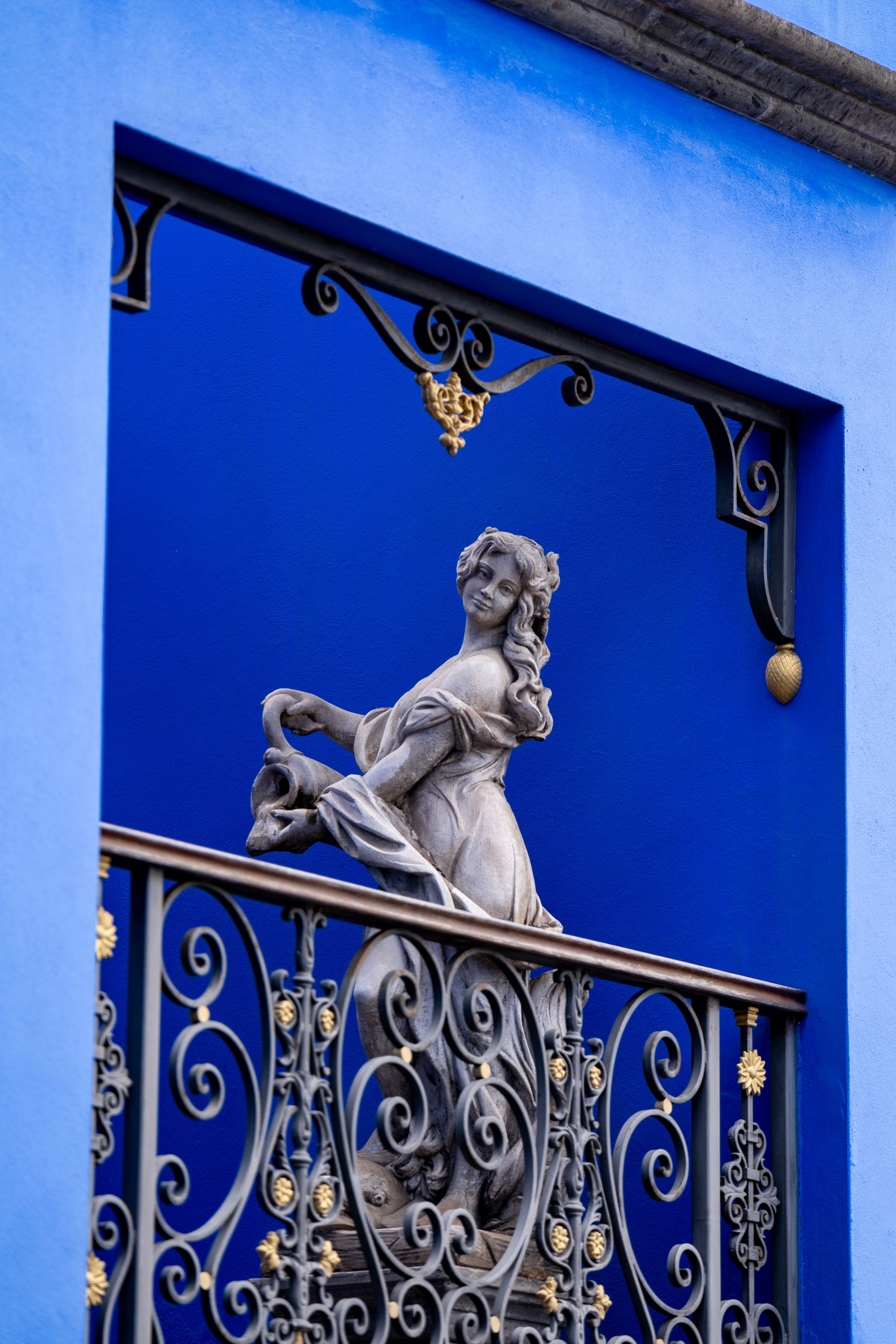 Statue on a Balcony in Blue Building · Free Stock Photo