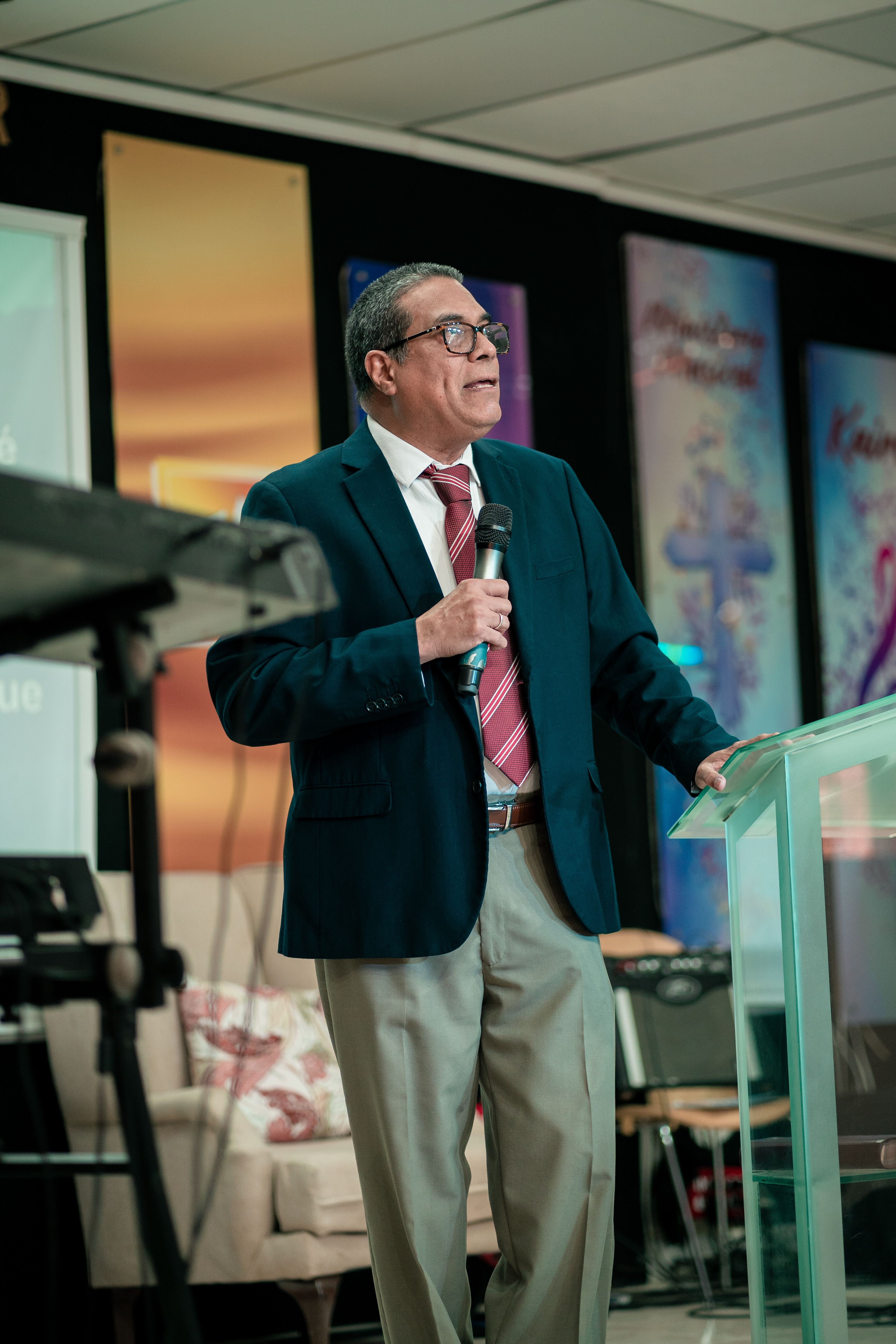 Man with Microphone Leaning Over Lectern · Free Stock Photo