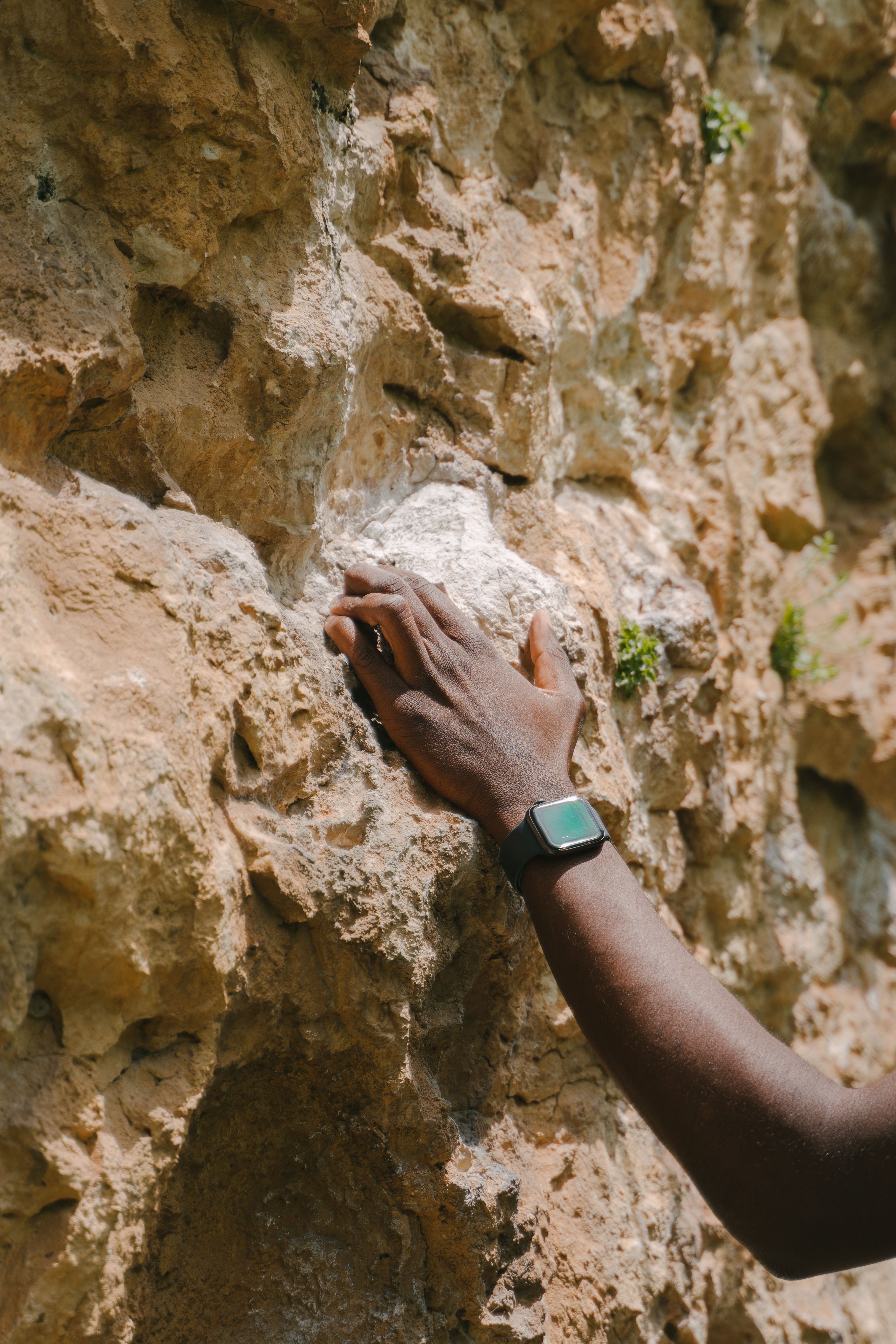 A person reaching out to touch a rock wall · Free Stock Photo