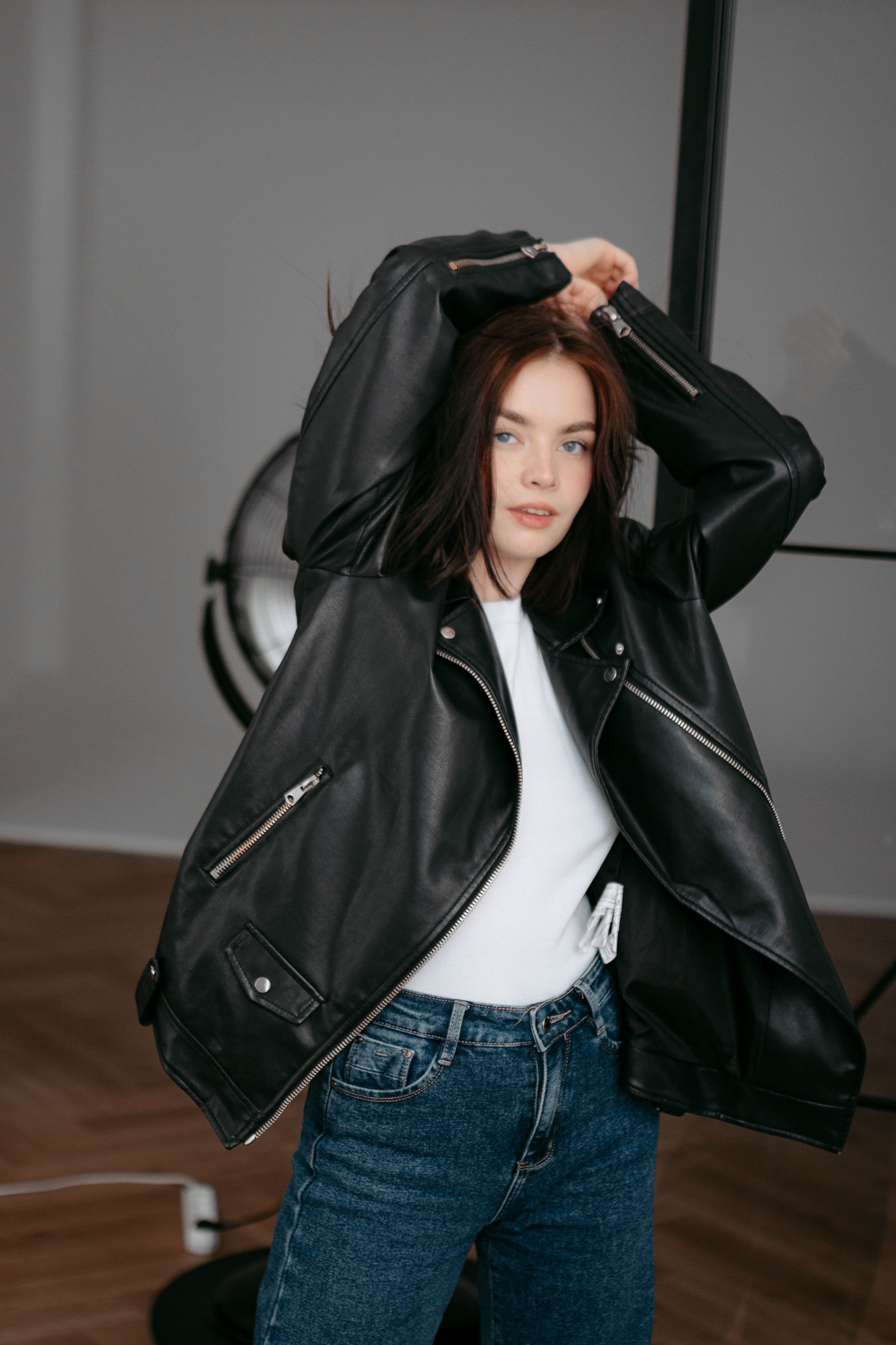 Woman in Black Jacket Posing with Arms Raised · Free Stock Photo