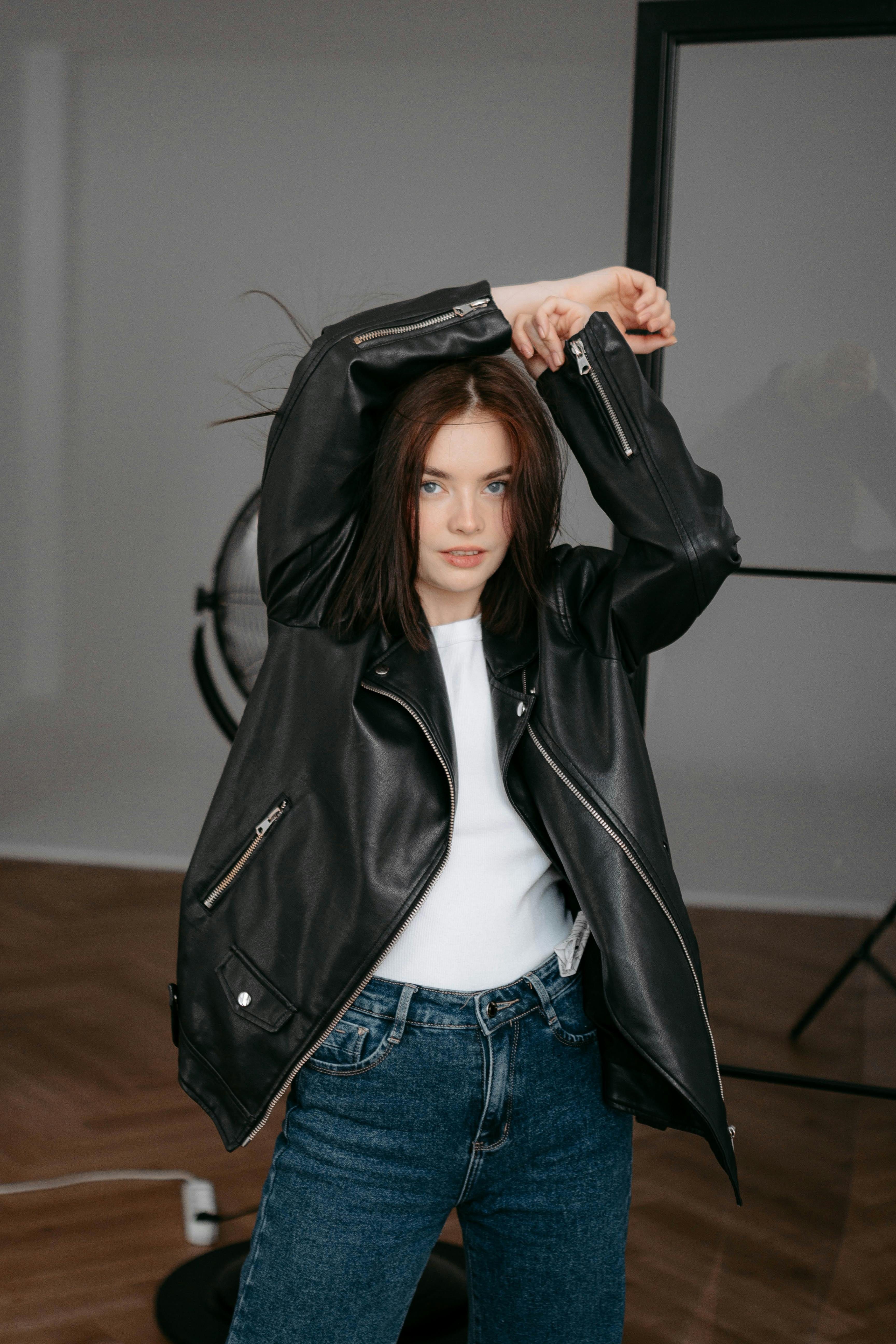 Brunette Woman in Leather Jacket Posing with Arms Raised · Free Stock Photo