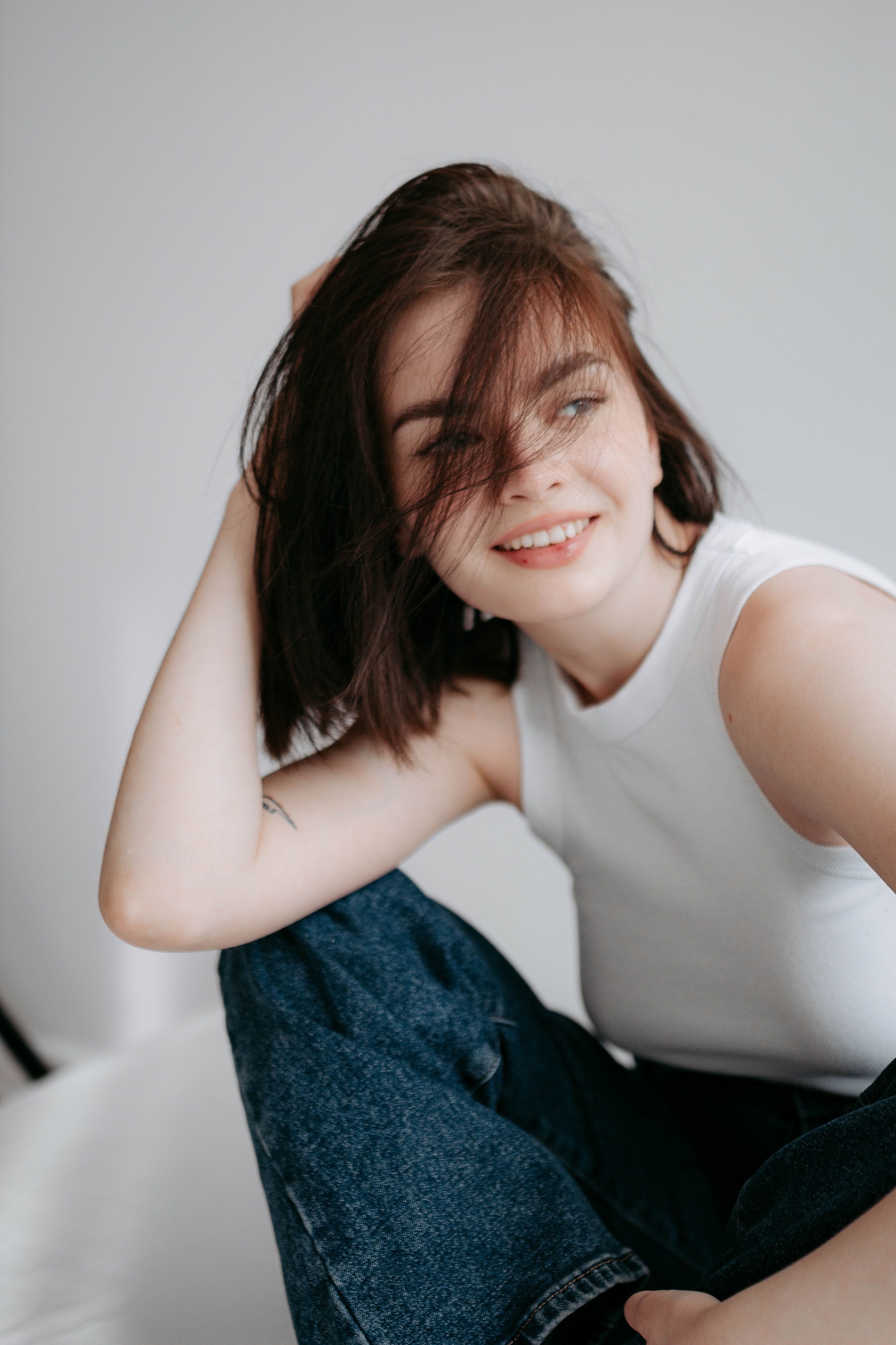 Smiling Woman Ruffling her Hair · Free Stock Photo