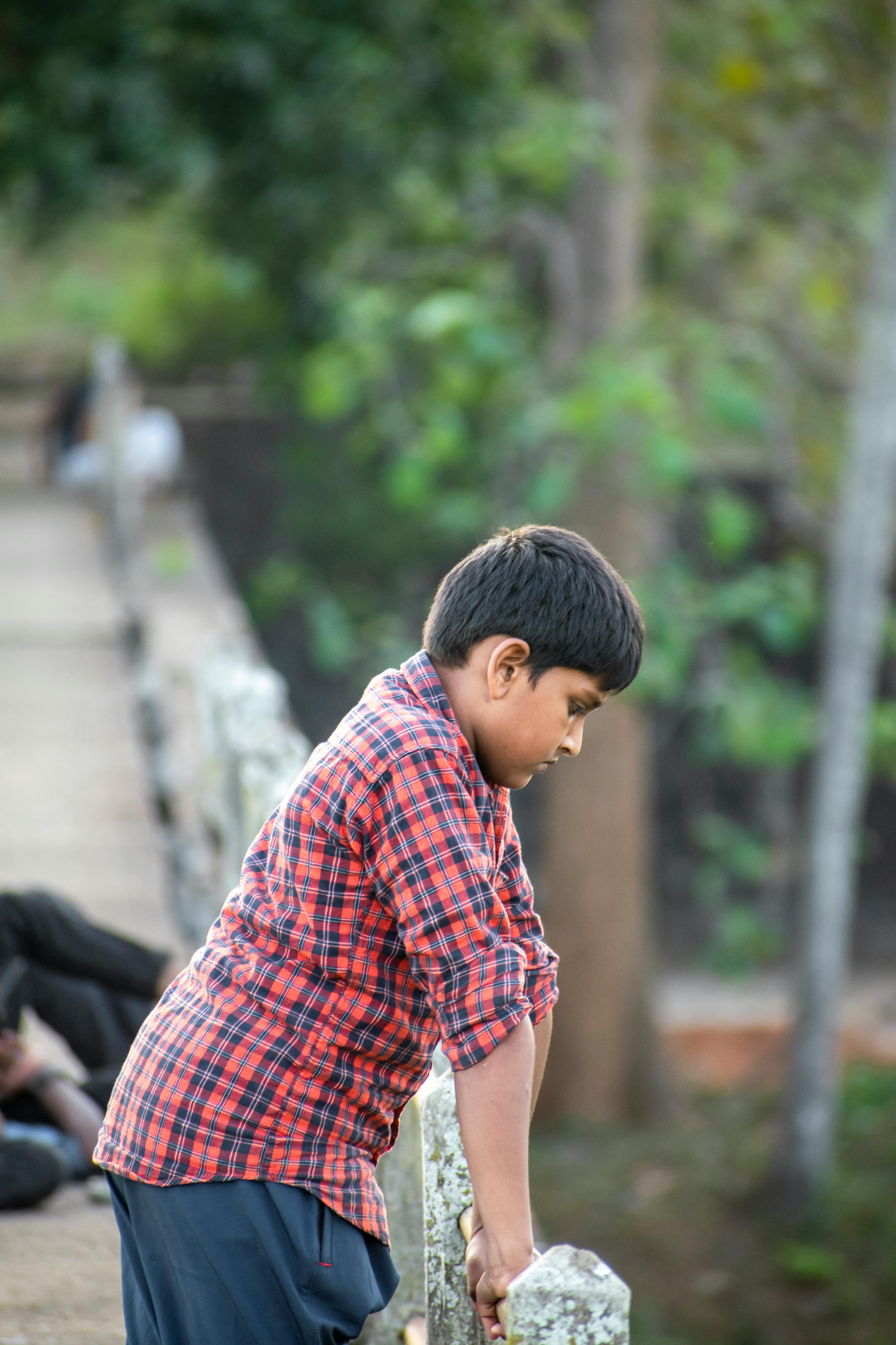 Boy Standing and Looking Down · Free Stock Photo