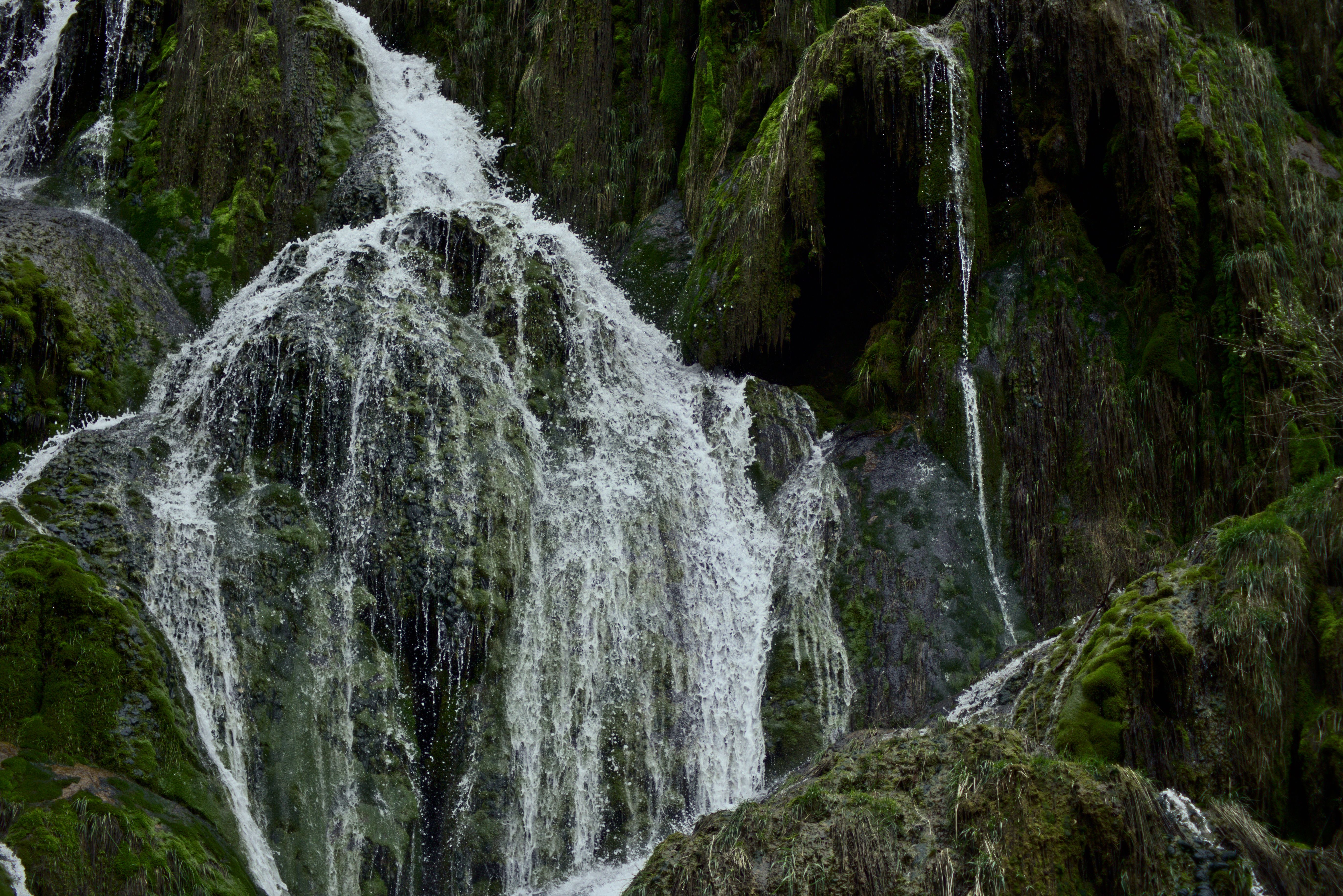A Waterfall on a Rocky Cliff Covered in Moss · Free Stock Photo