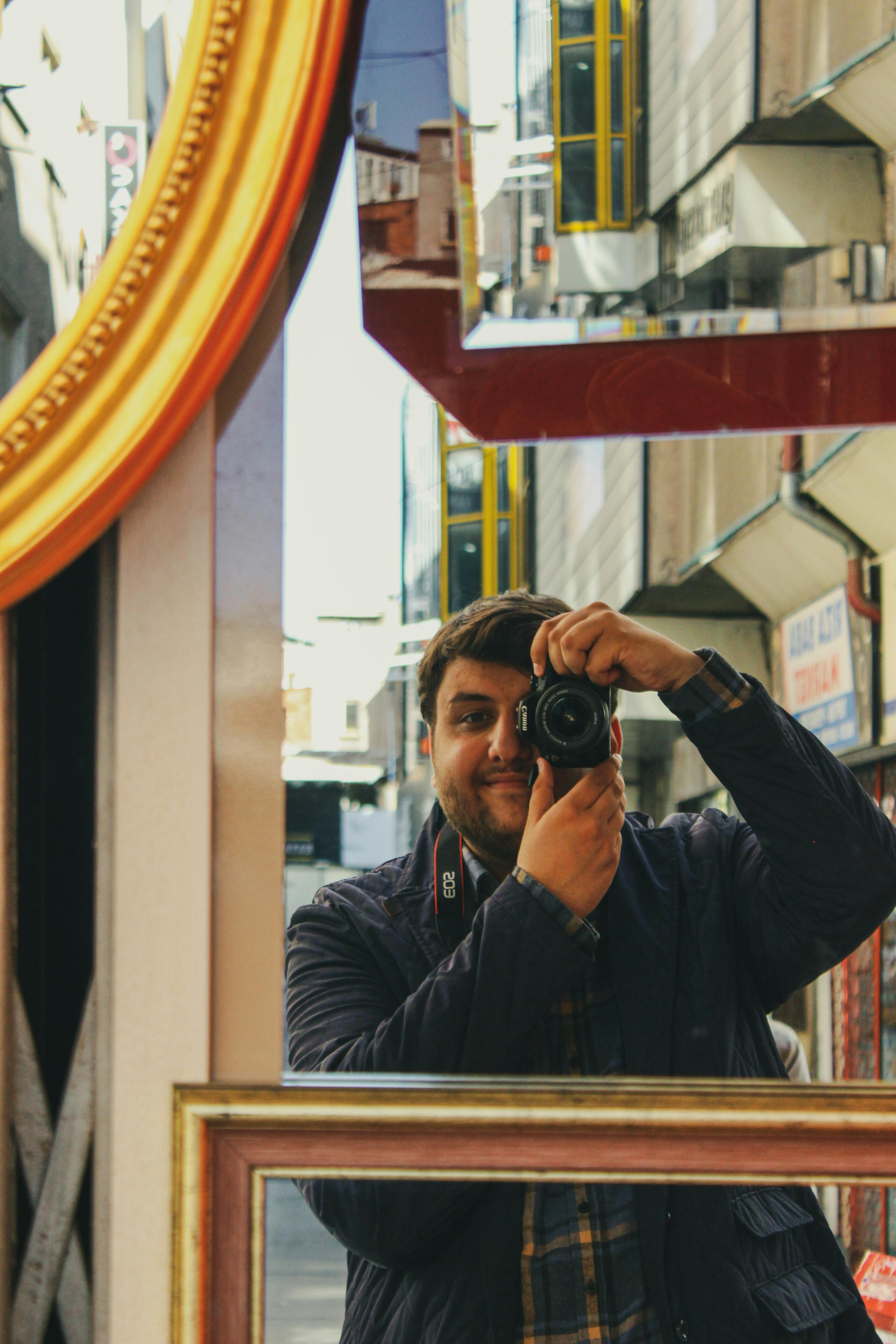 Smiling Man Taking Pictures with Camera behind Window · Free Stock Photo