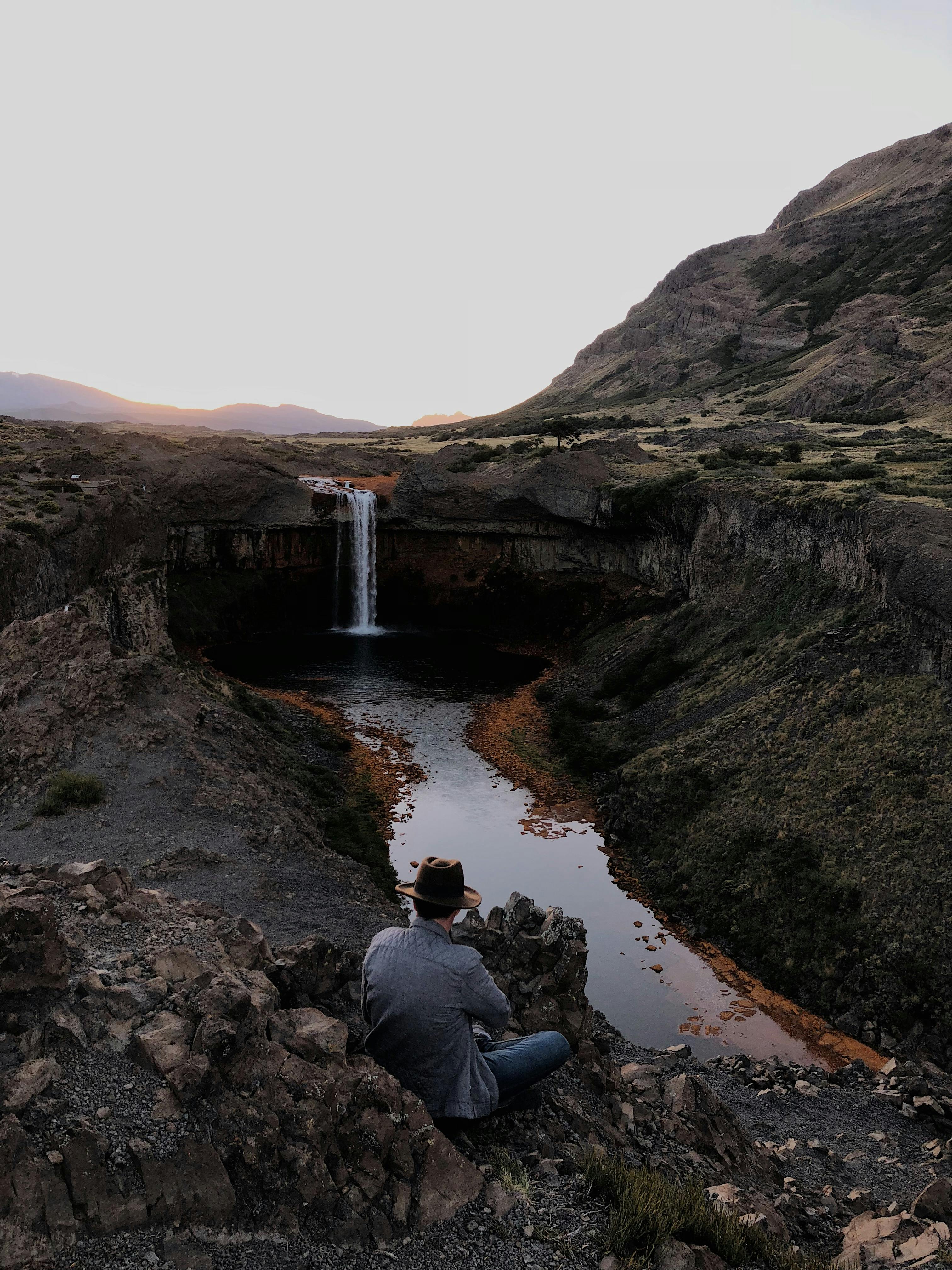 Man Sitting Near Waterfalls · Free Stock Photo