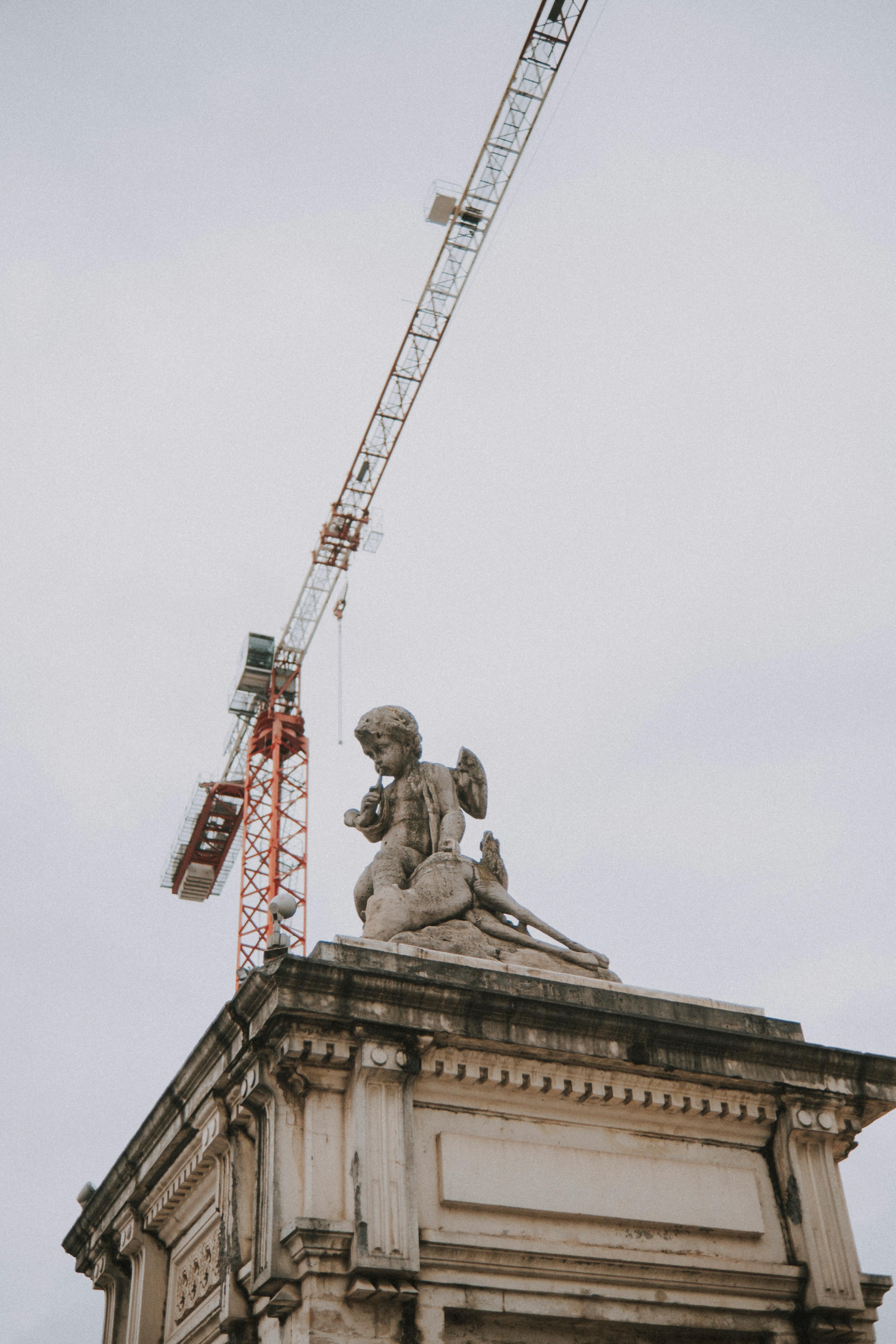 Crane over Tower with Angel Figure · Free Stock Photo