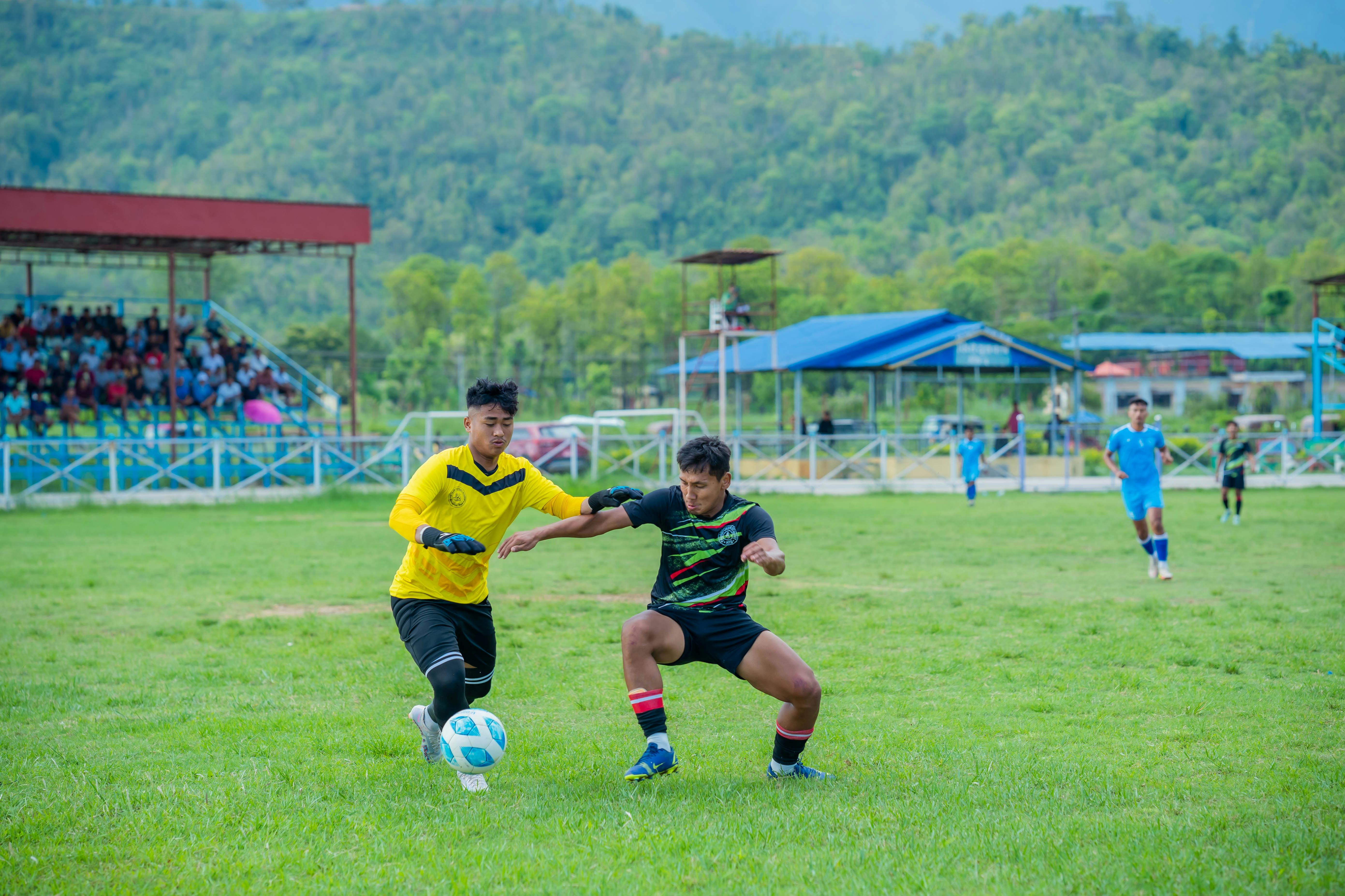 Men Playing Football on Stadium in Village · Free Stock Photo