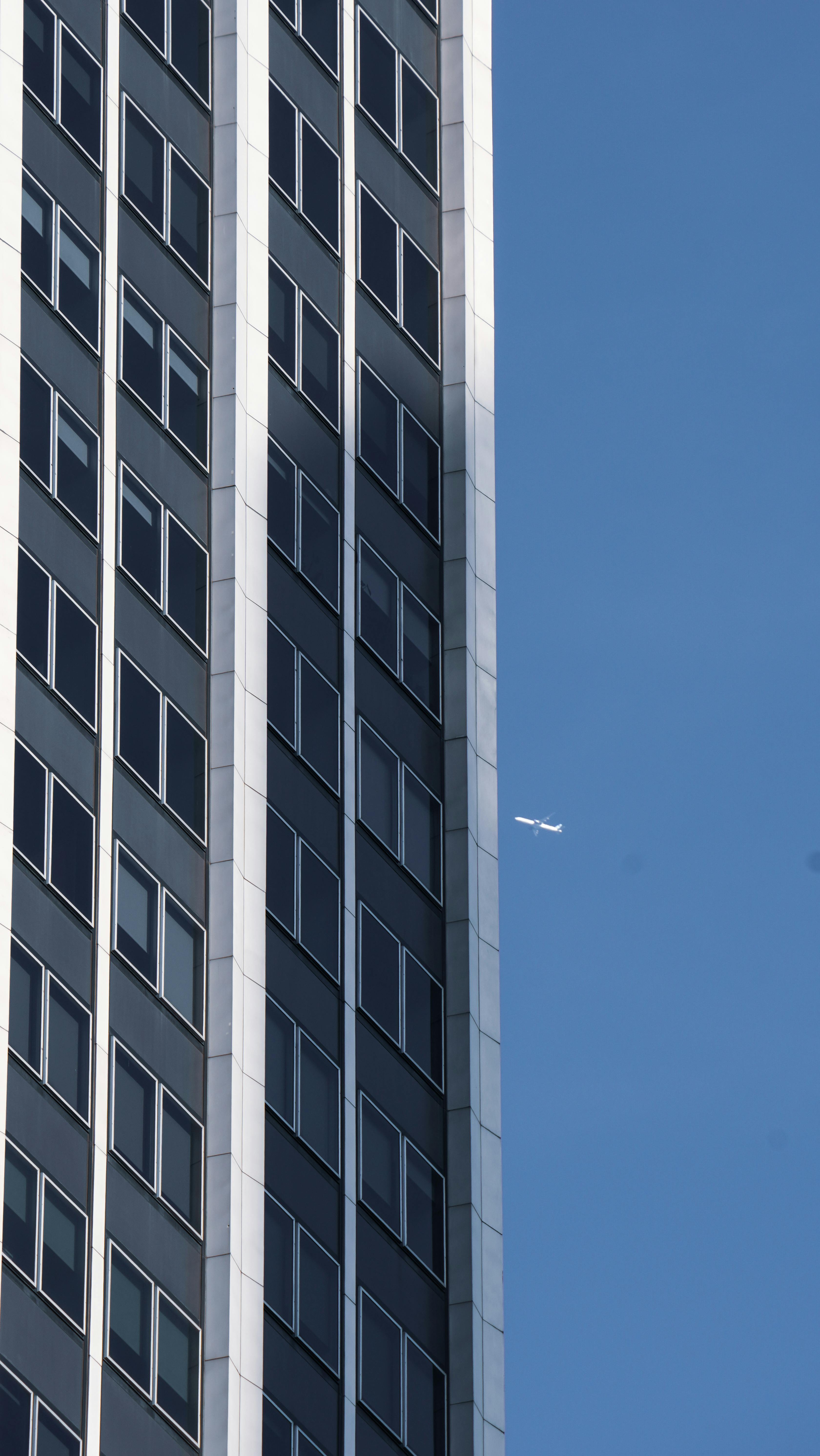 Skyscraper Facade and Airplane in the Sky · Free Stock Photo