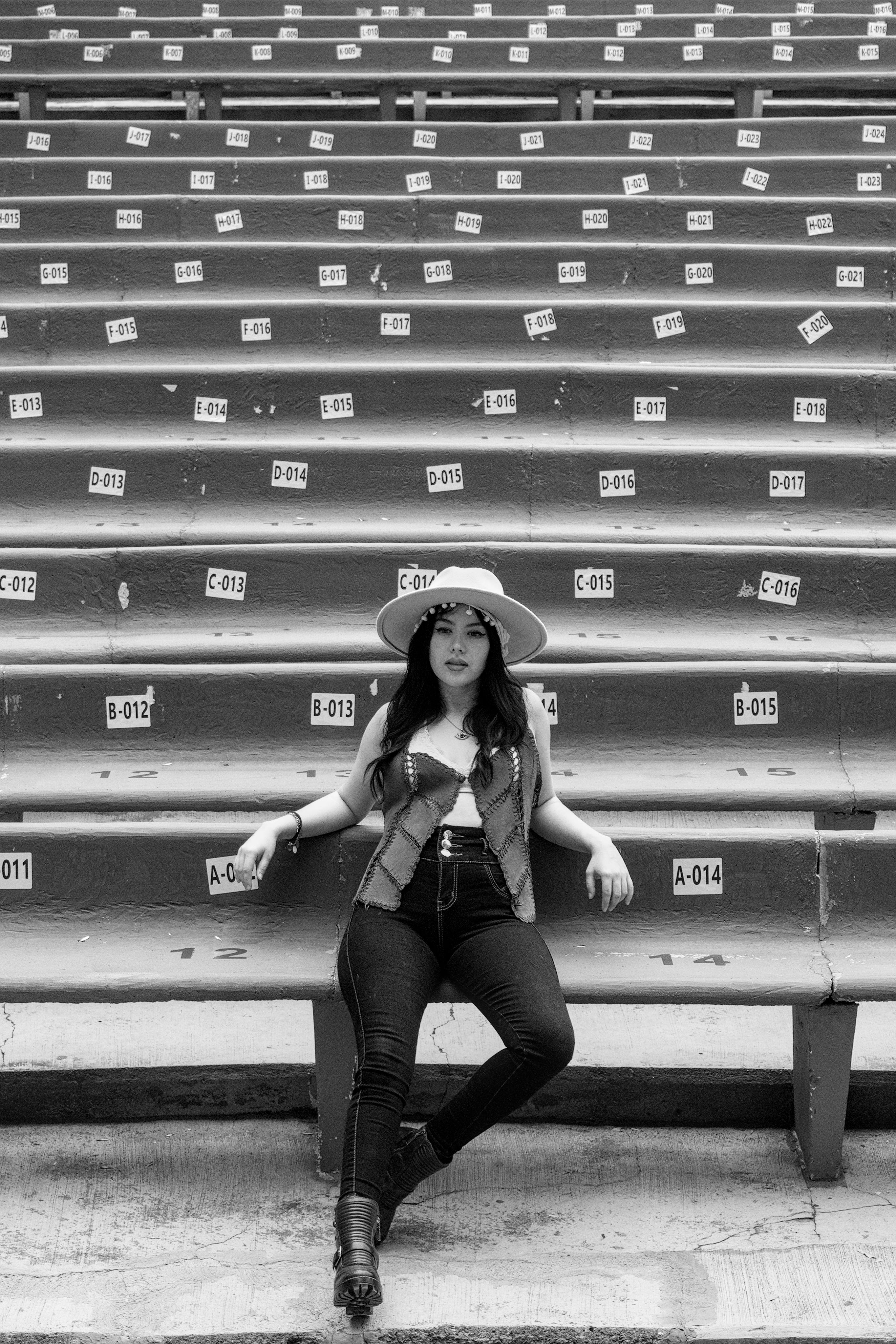 Black and White Photo of a Woman Sitting on a Bench in an Auditorium ...