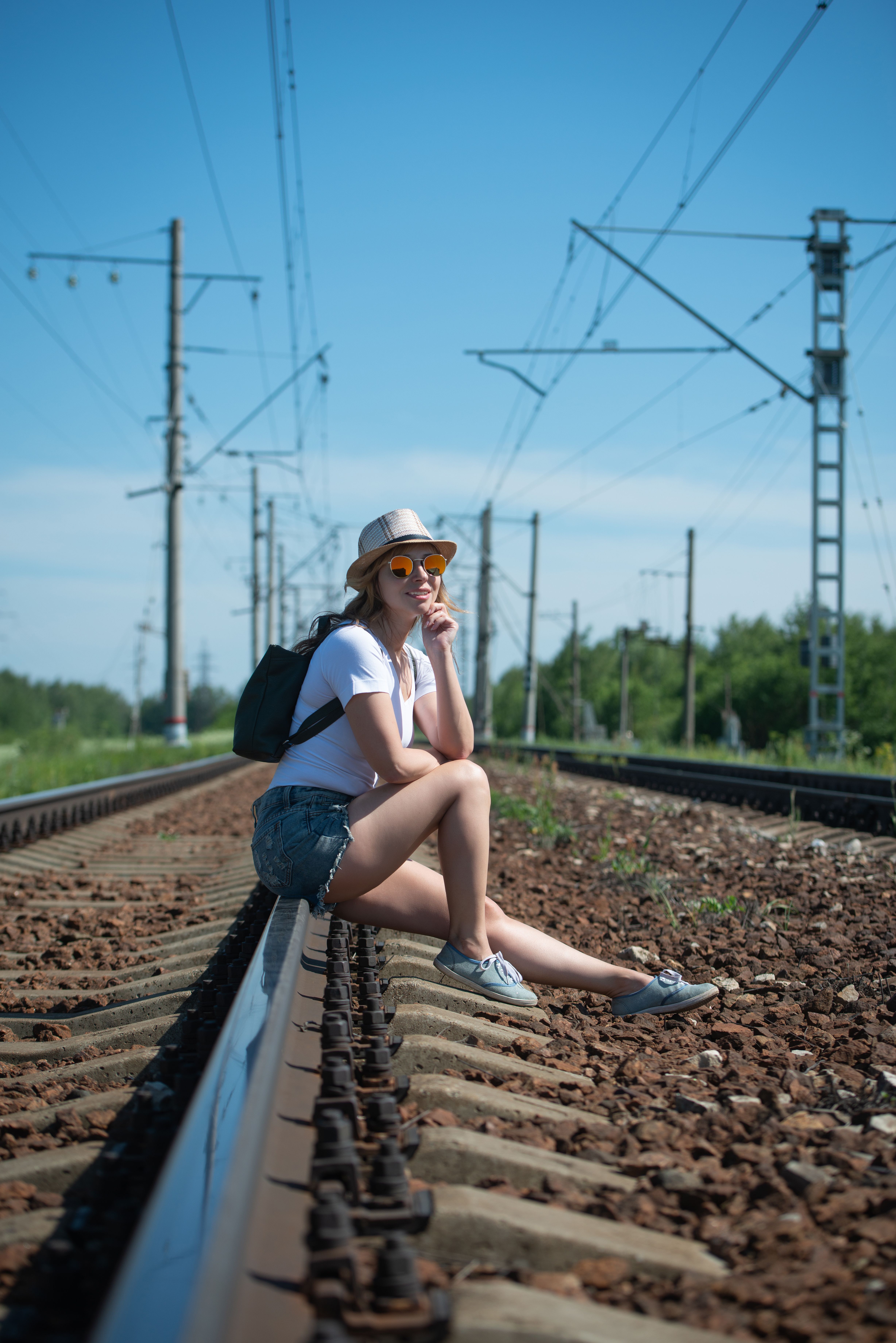 Smiling Man Sitting on Train Tracks · Free Stock Photo