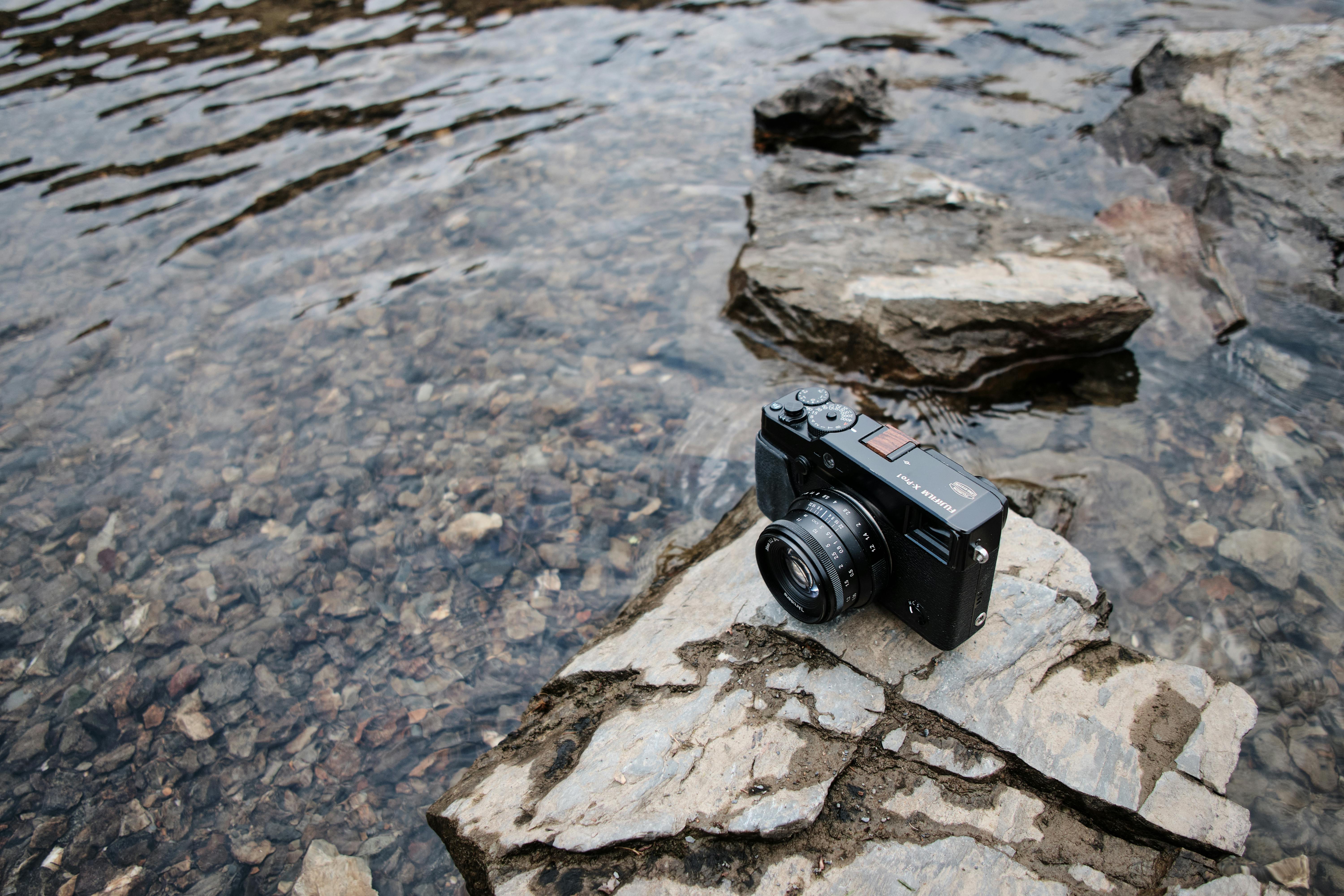 Camera on Stones on Water · Free Stock Photo