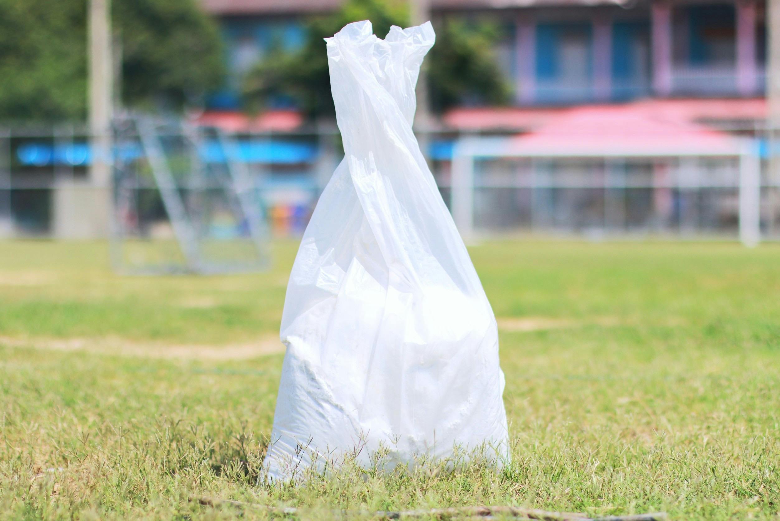 Photo Of Trash Bag On Sand · Free Stock Photo