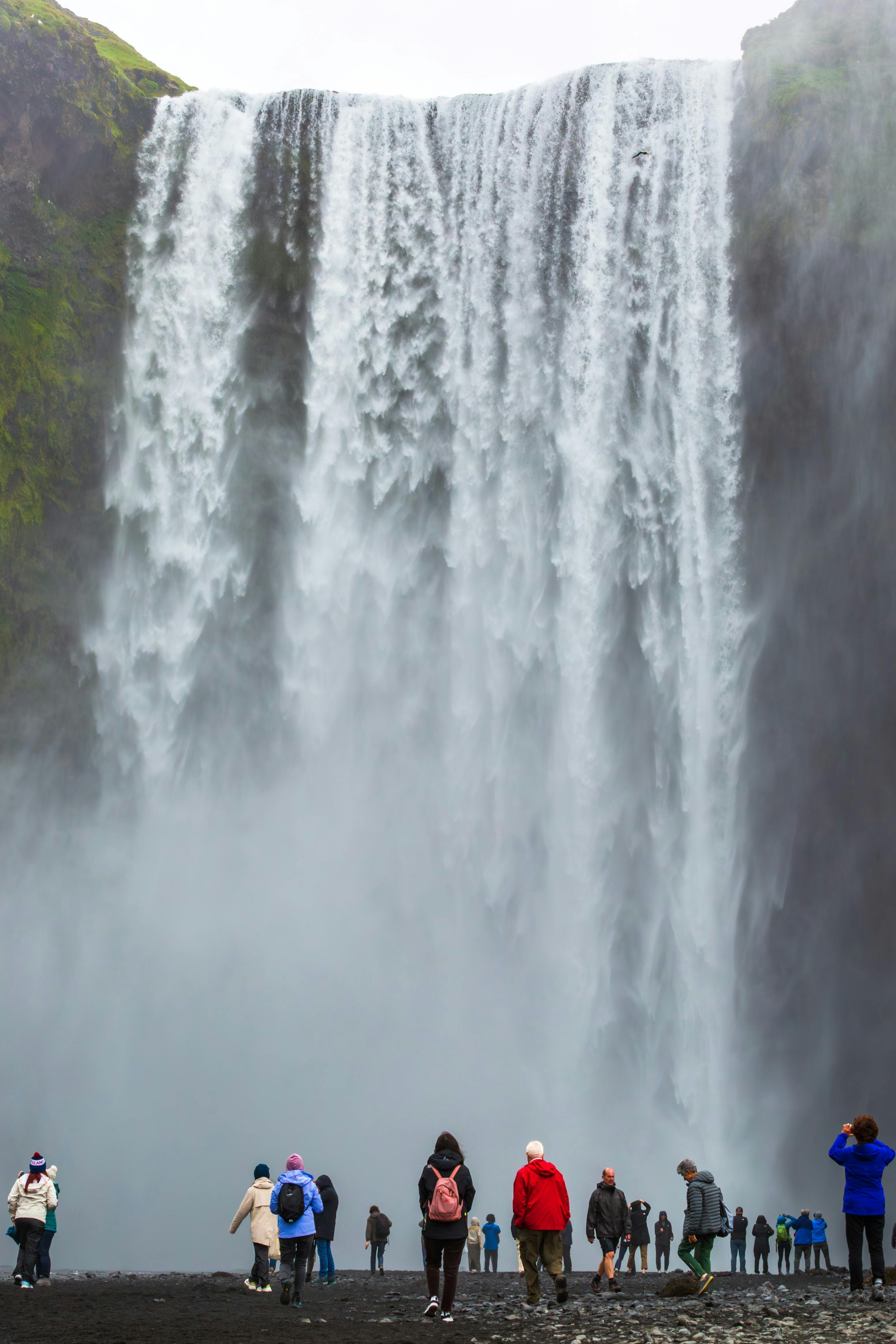 People Standing under Waterfall · Free Stock Photo
