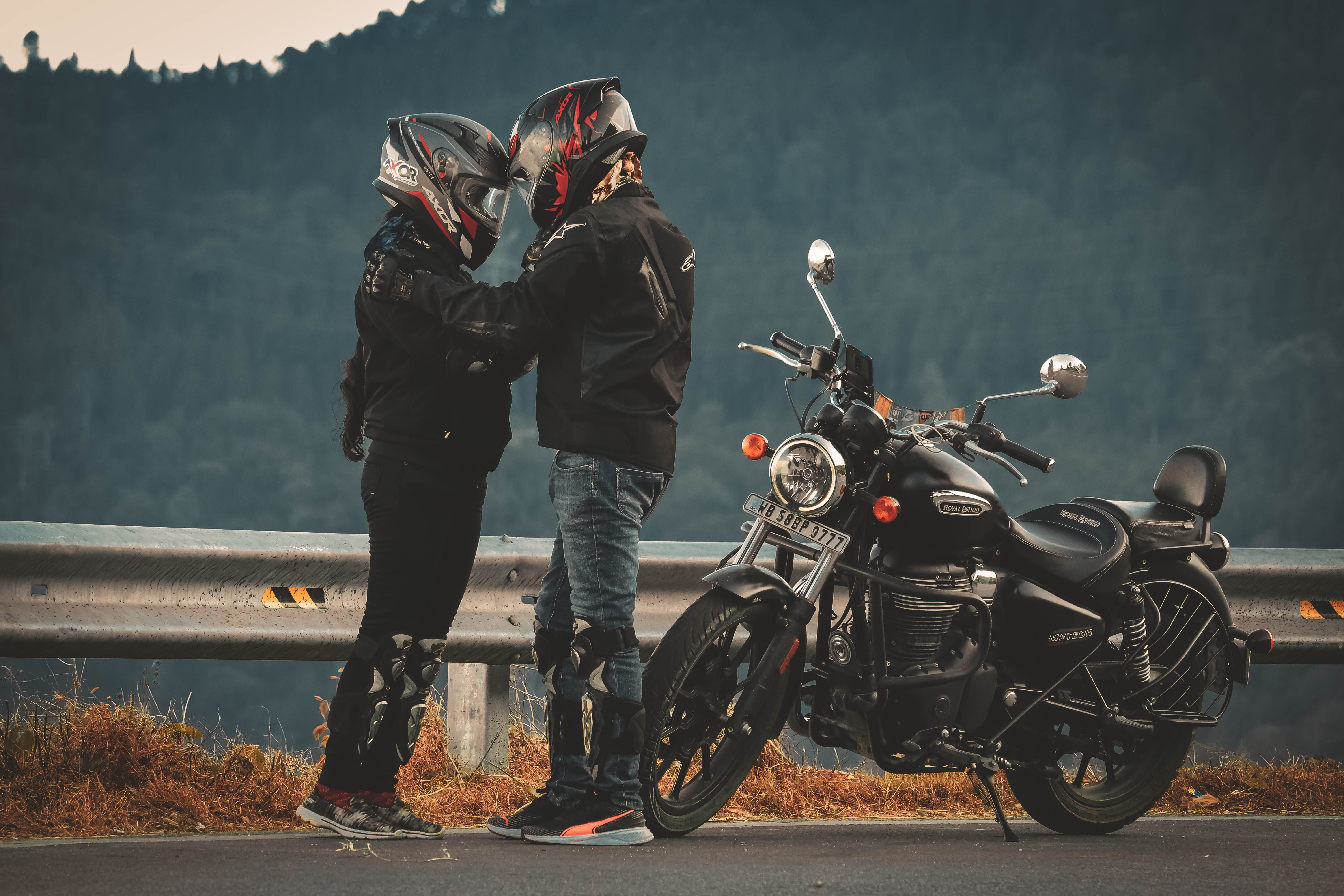 A Couple in Helmets Standing next to a Motorcycle · Free Stock Photo