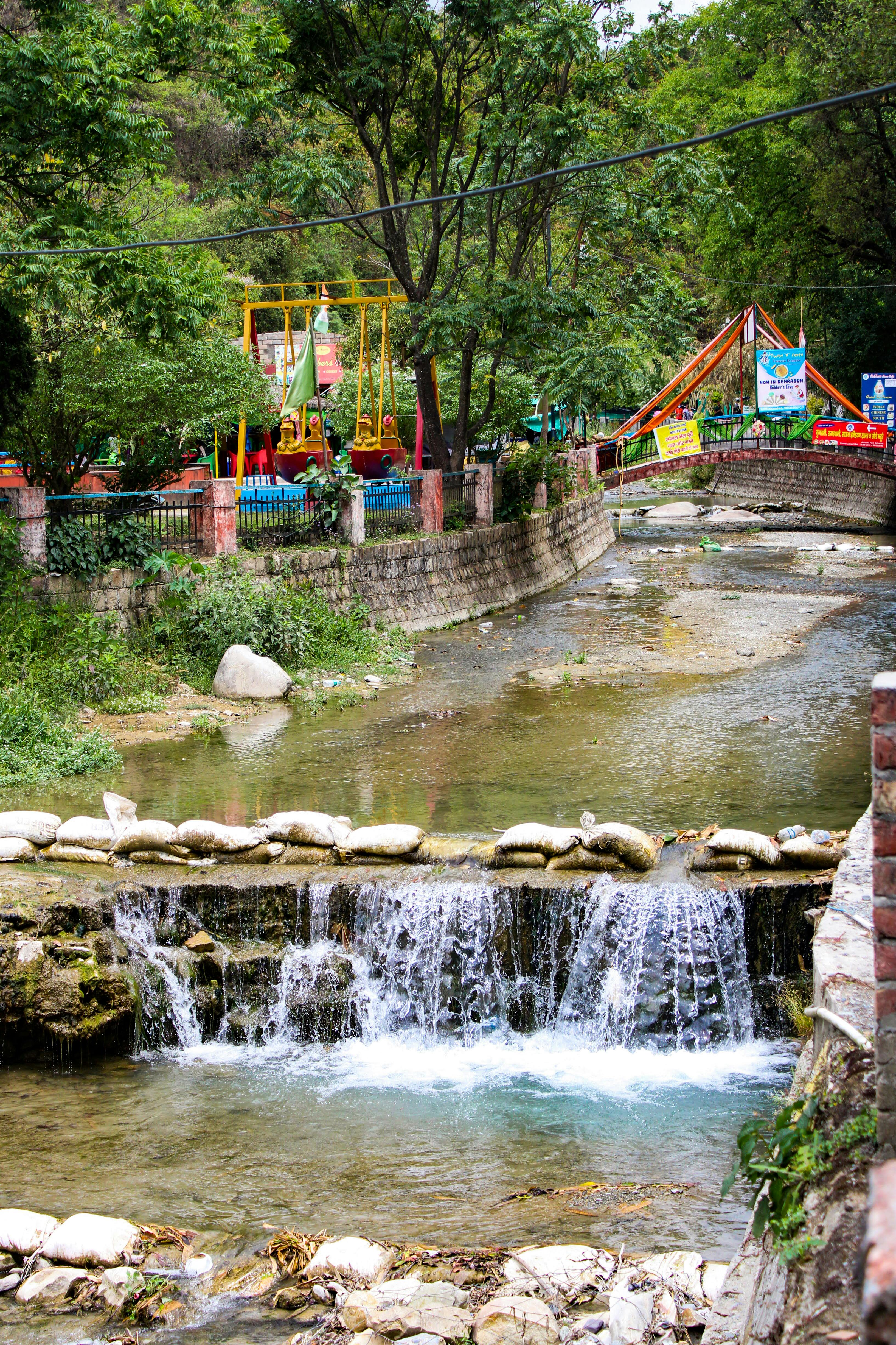 View of a Small Waterfall near a Playground in a Park · Free Stock Photo