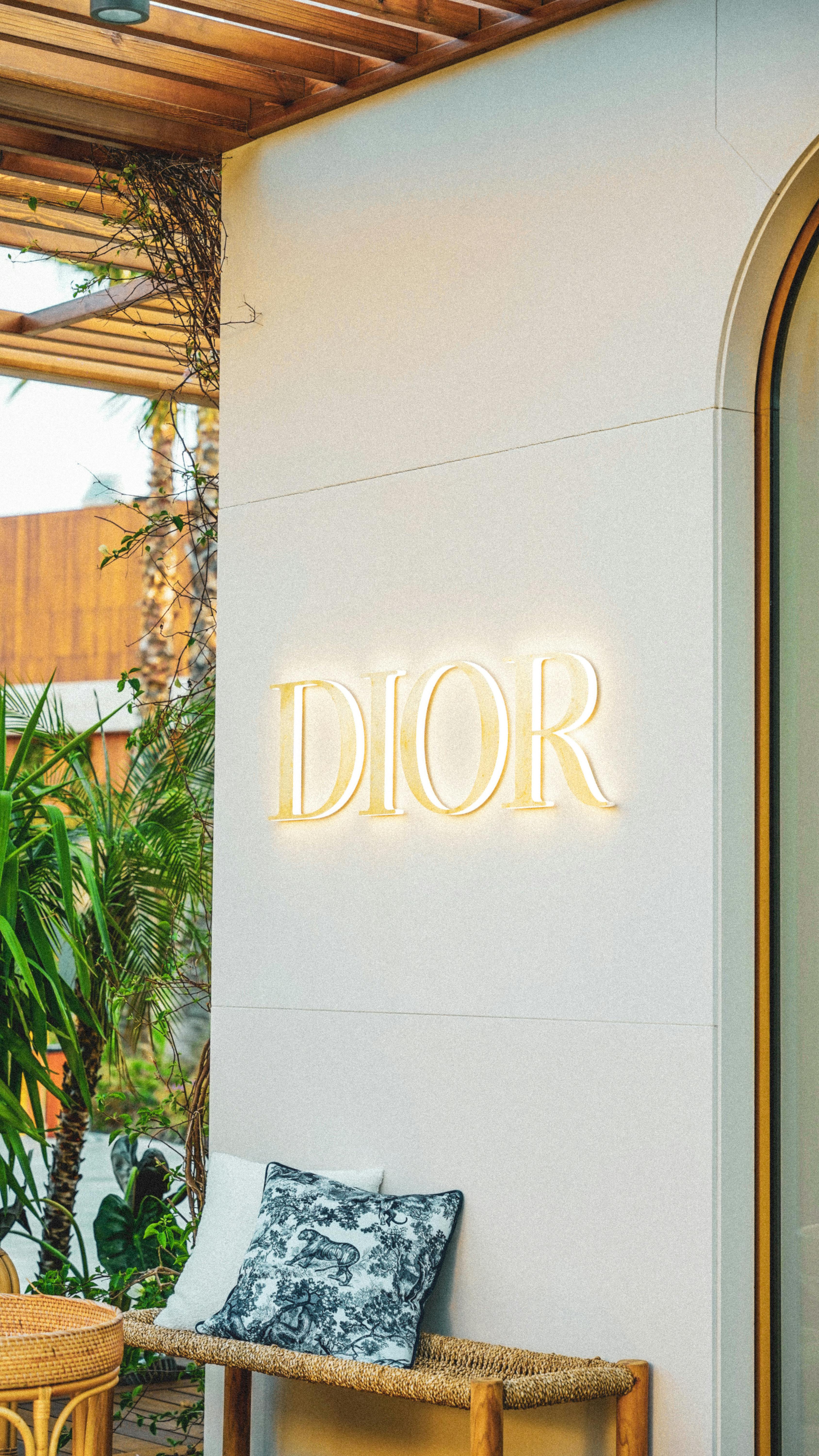 Glowing Dior Sign Hanging Outdoors · Free Stock Photo