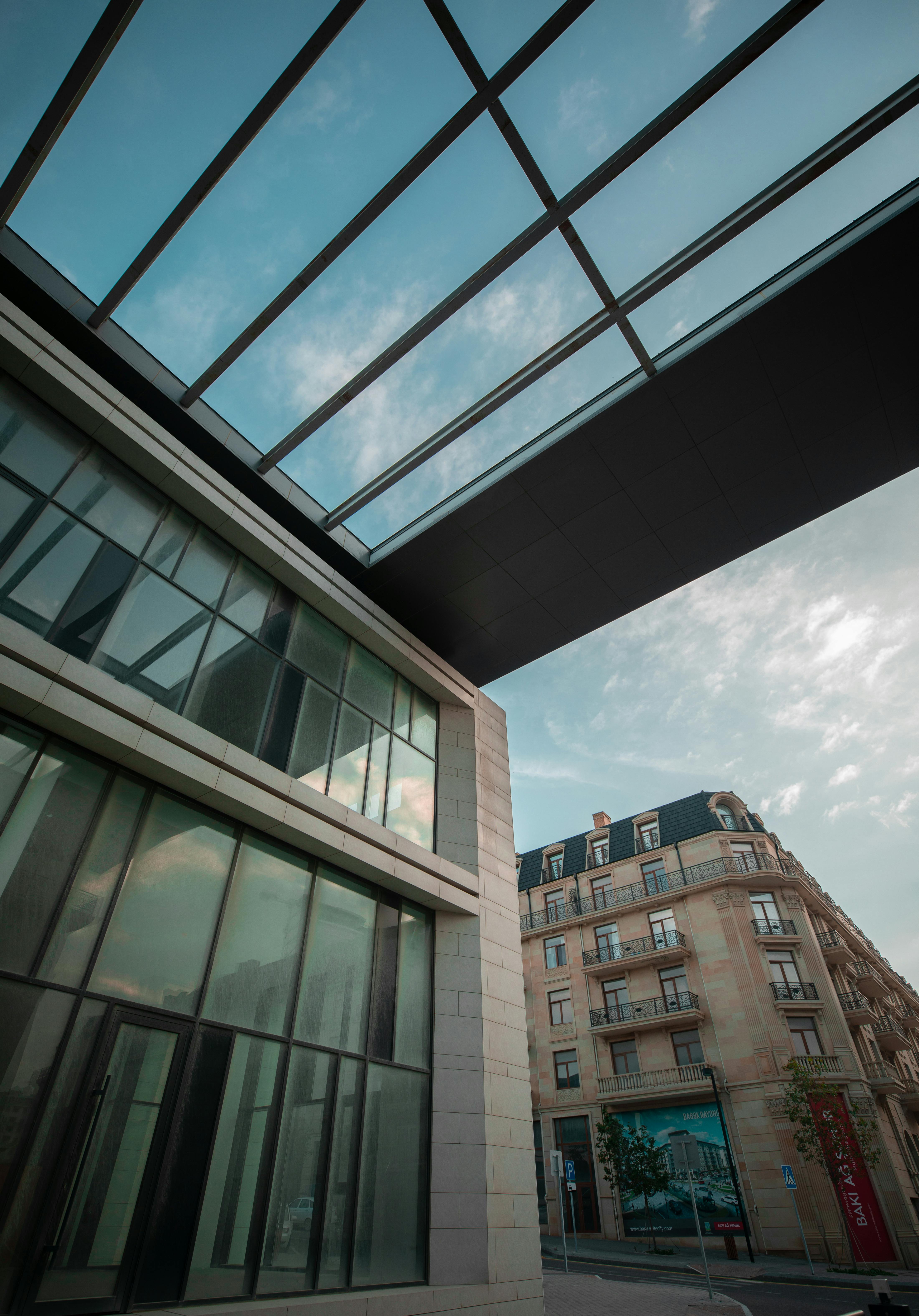 The building has glass windows and a large glass roof · Free Stock Photo