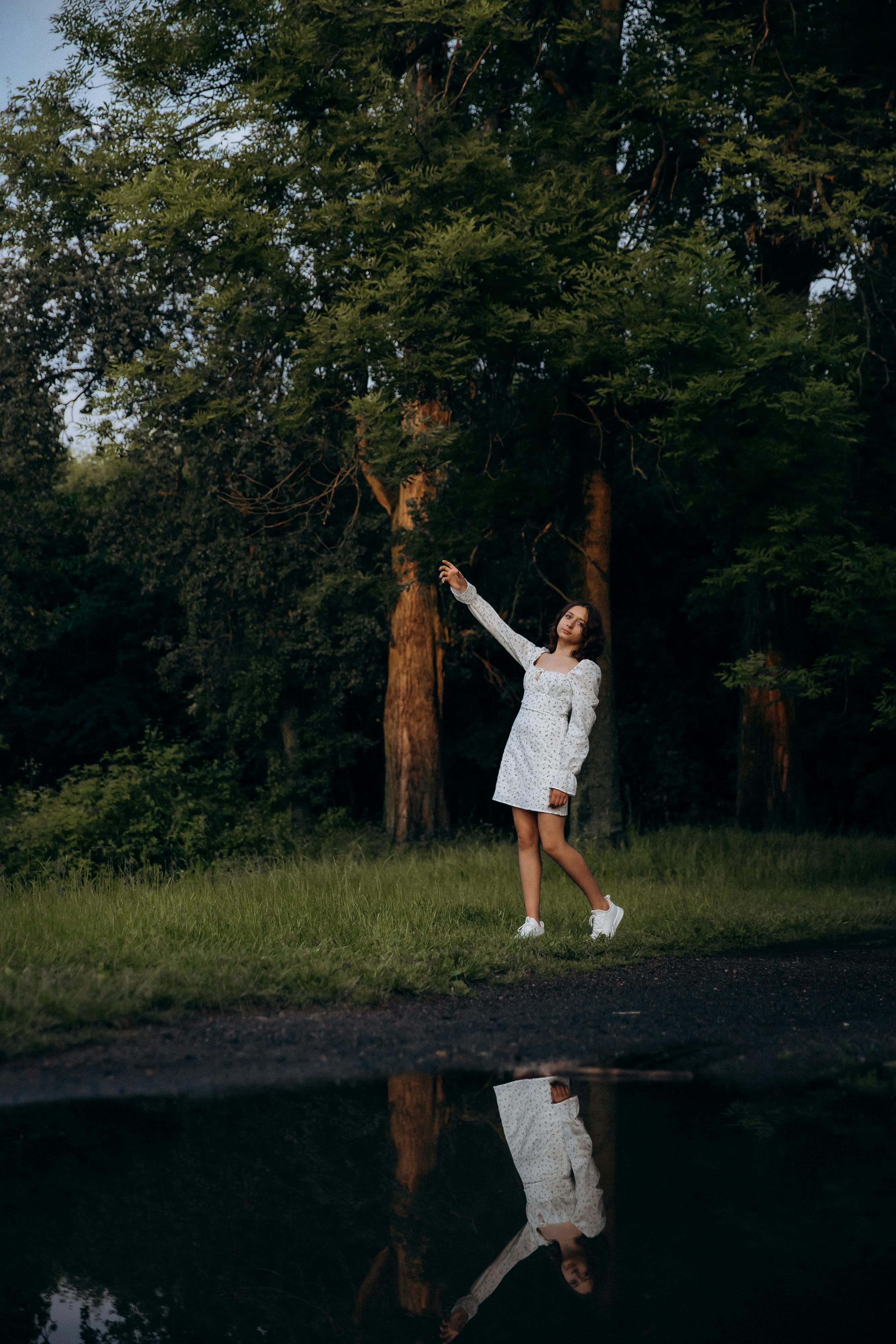 Woman in a White Dress and Trainers Standing on the Lakeshore · Free ...