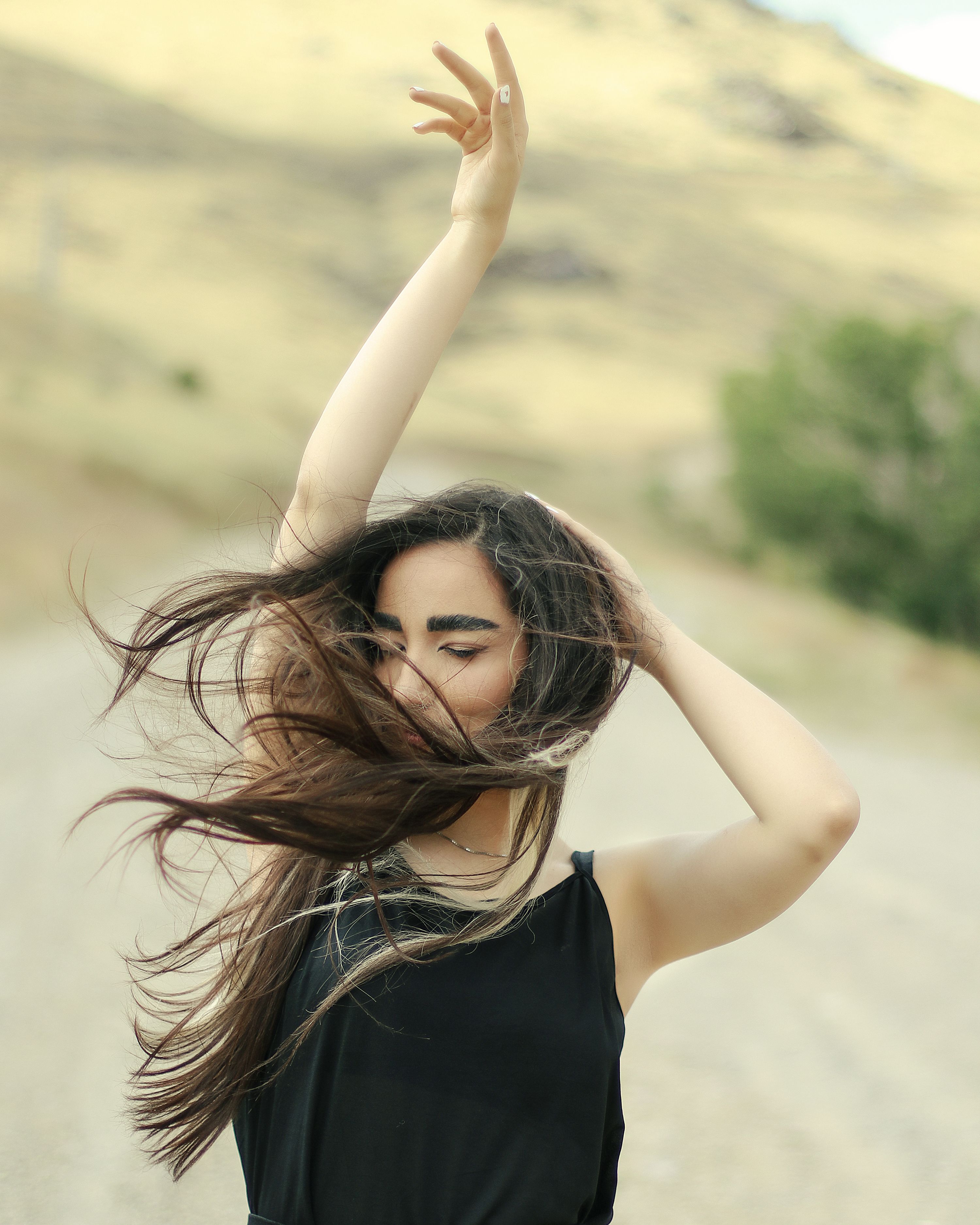 Woman with Arm Raised and Messy Hair · Free Stock Photo