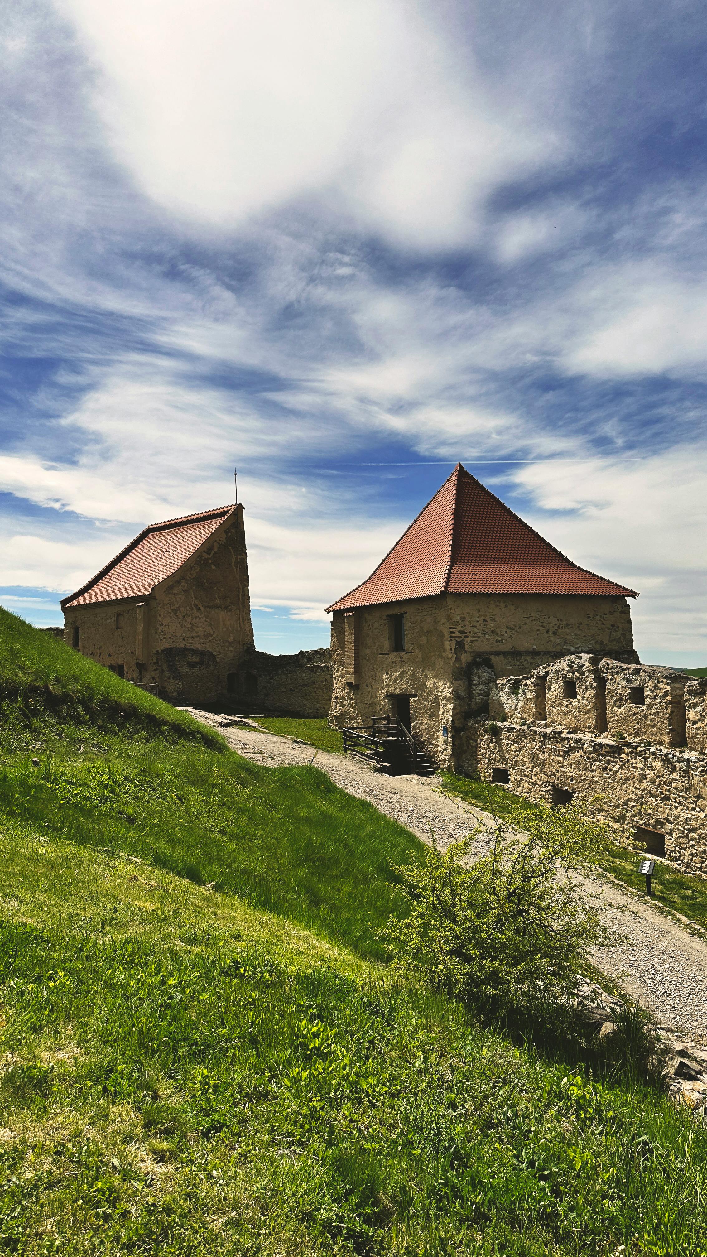 Two stone buildings on a grassy hillside · Free Stock Photo