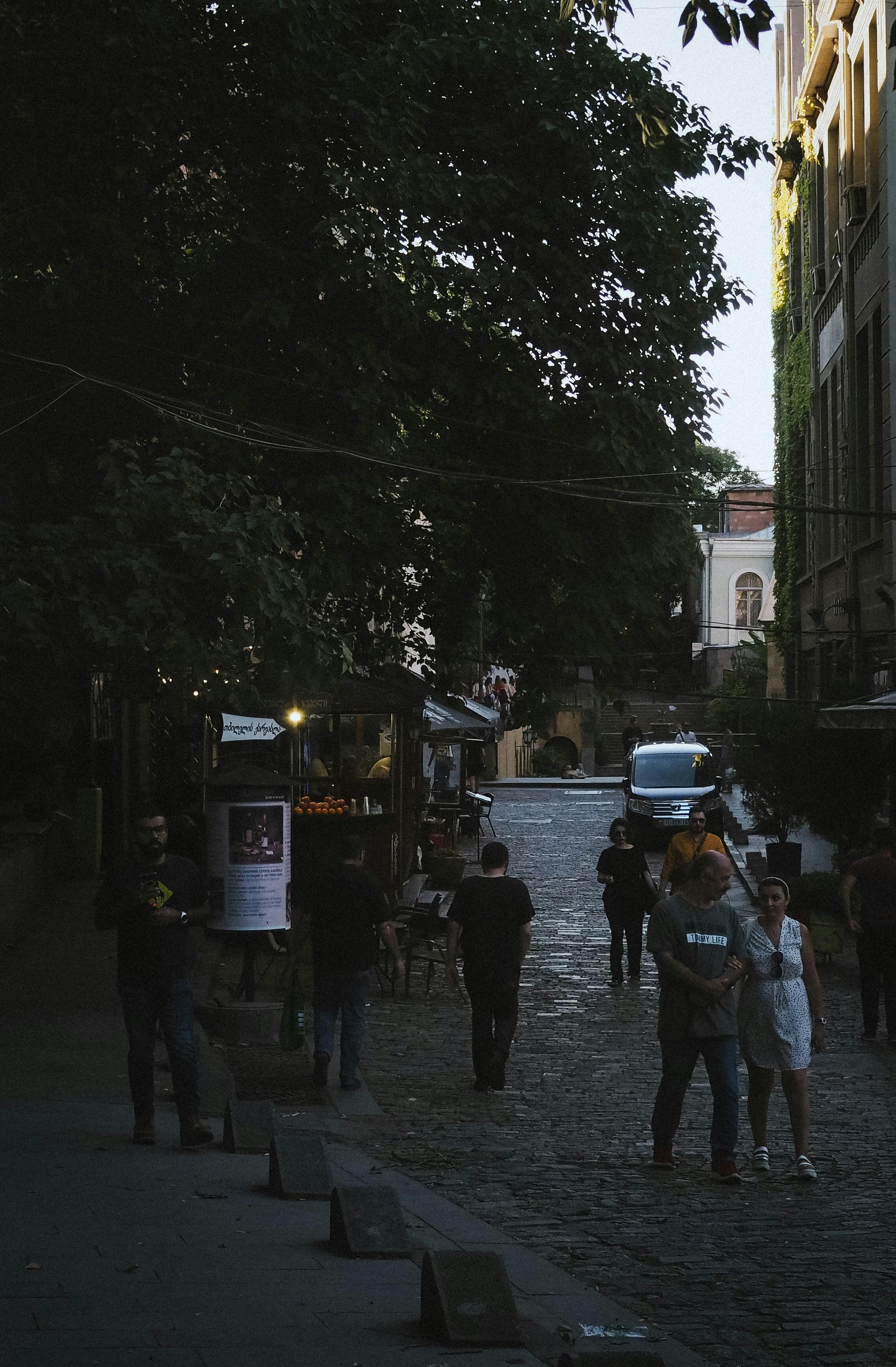 People Walking on Shadowed Street · Free Stock Photo