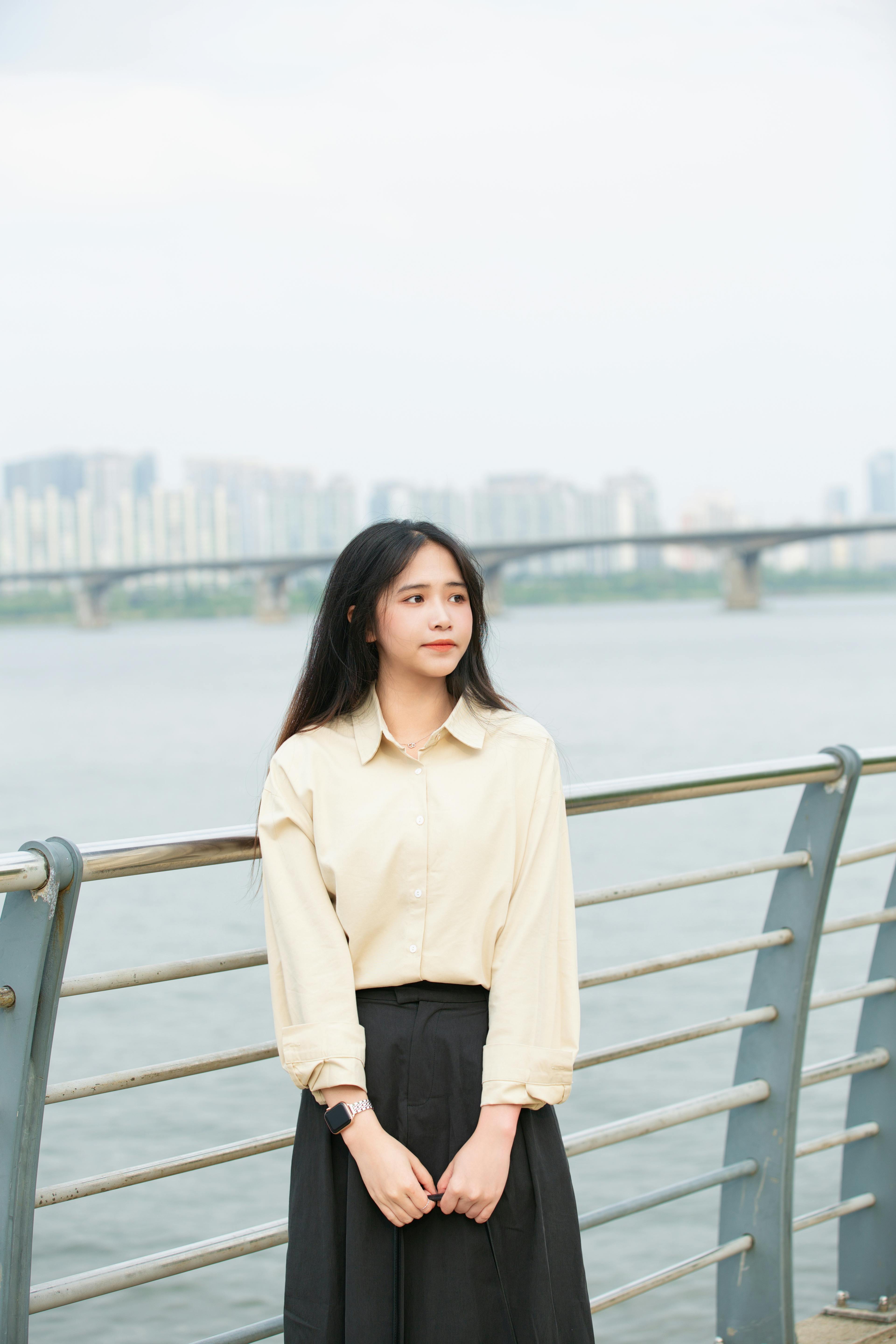 Woman in Shirt Standing near Railing over Water · Free Stock Photo