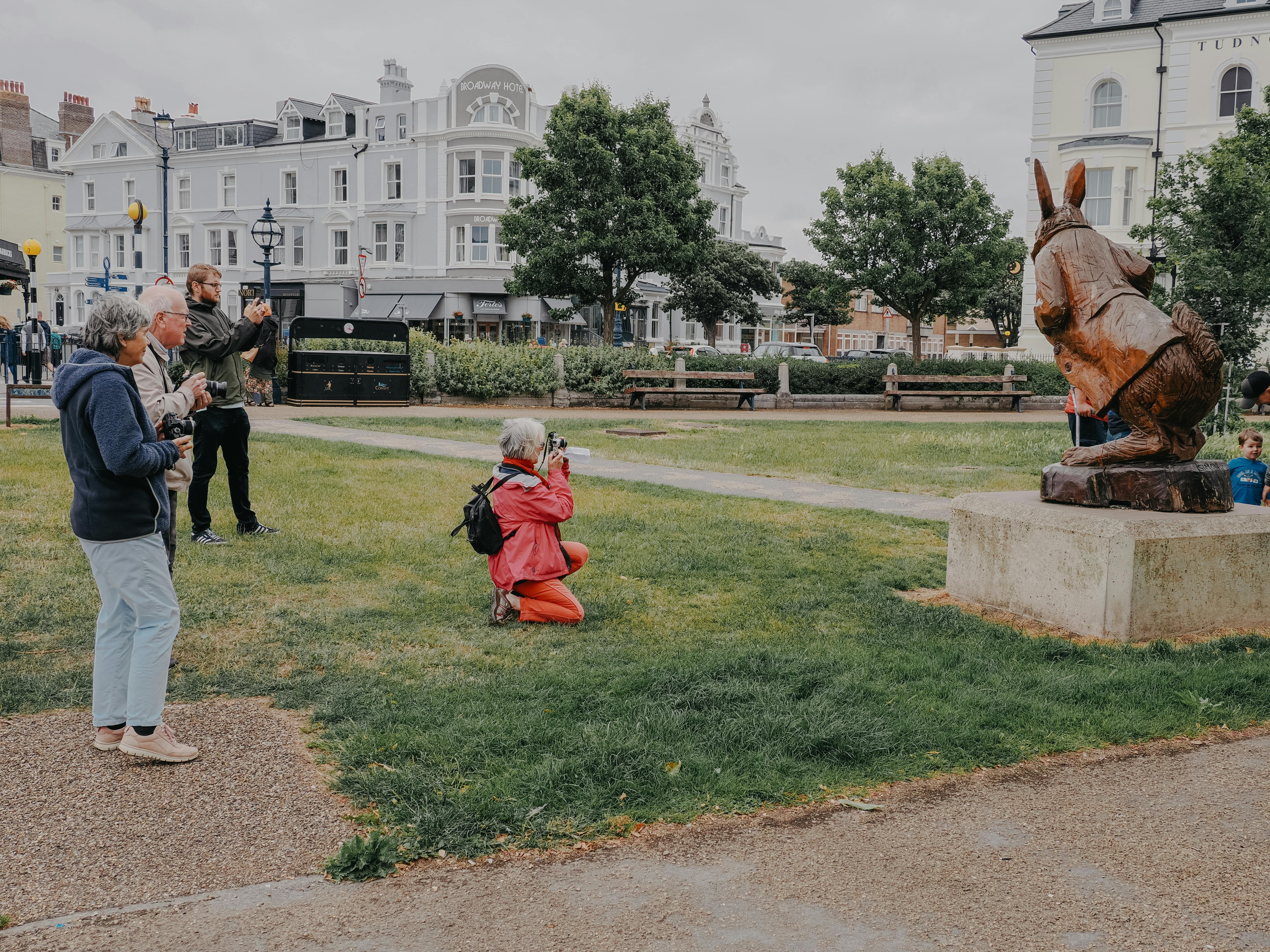 a group of people taking photographs of a rabiit statue · Free Stock Photo