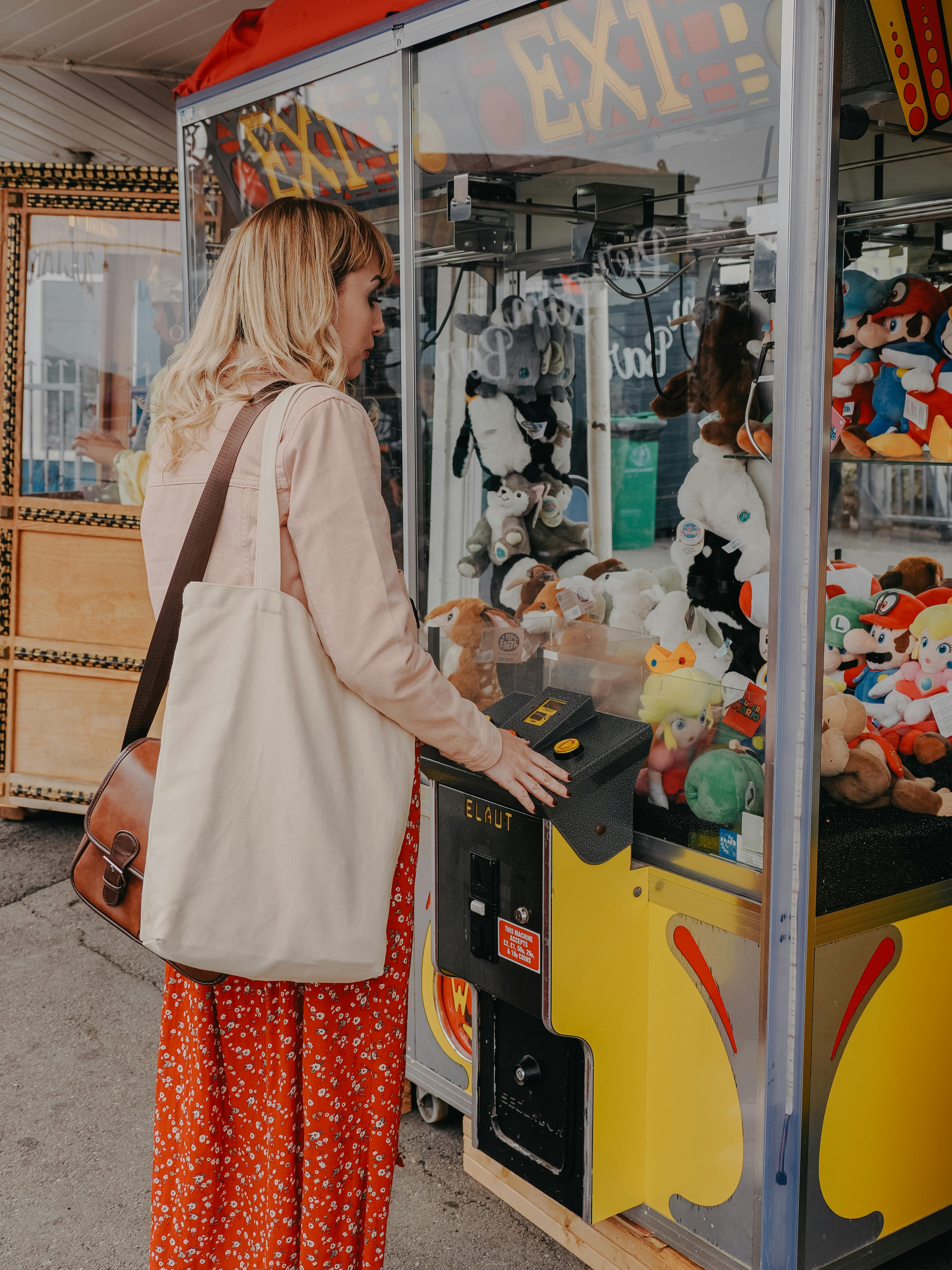 Woman Playing Arcade Machine with Toys · Free Stock Photo