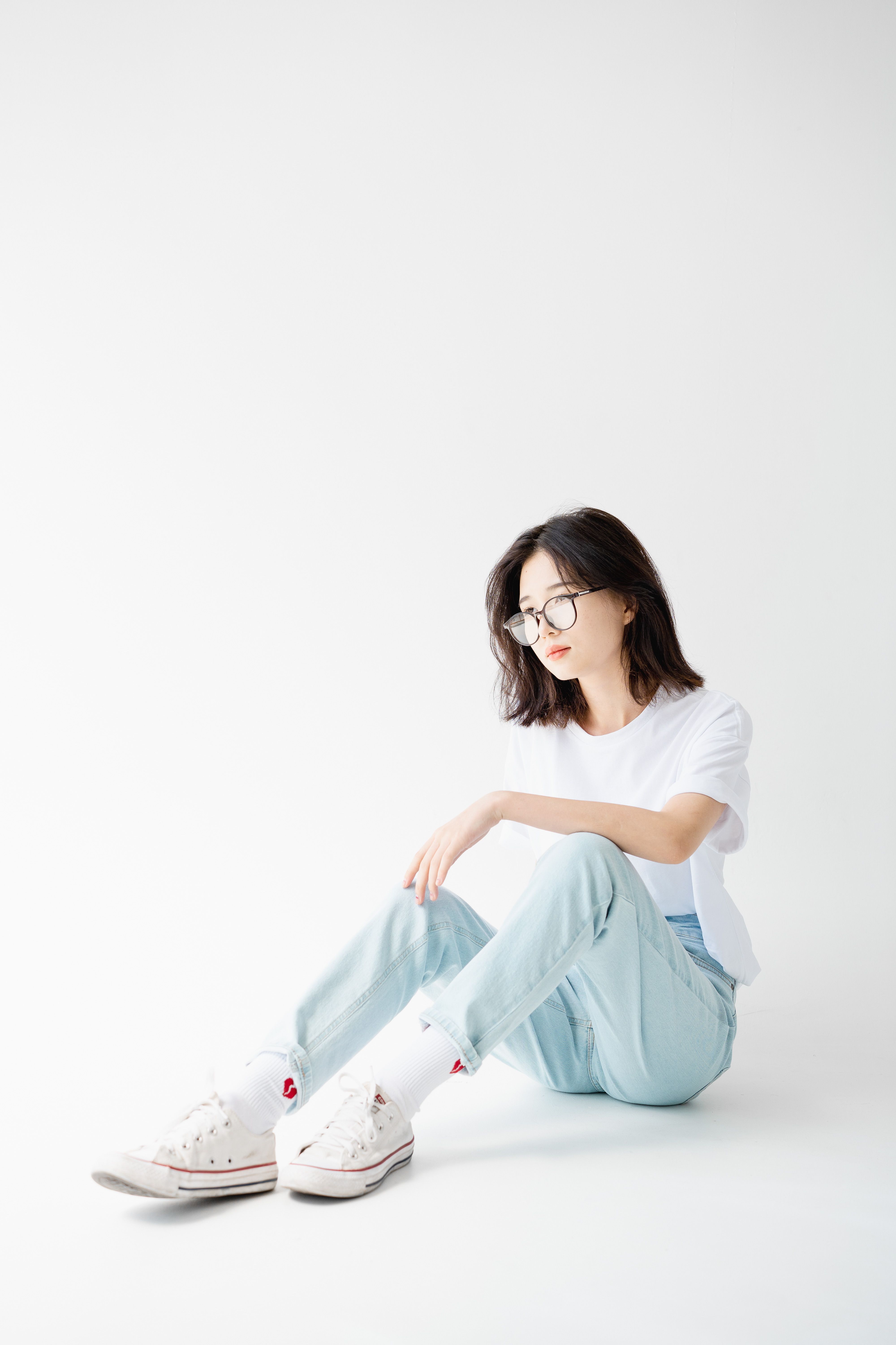 Woman Sitting and Posing on White Background · Free Stock Photo