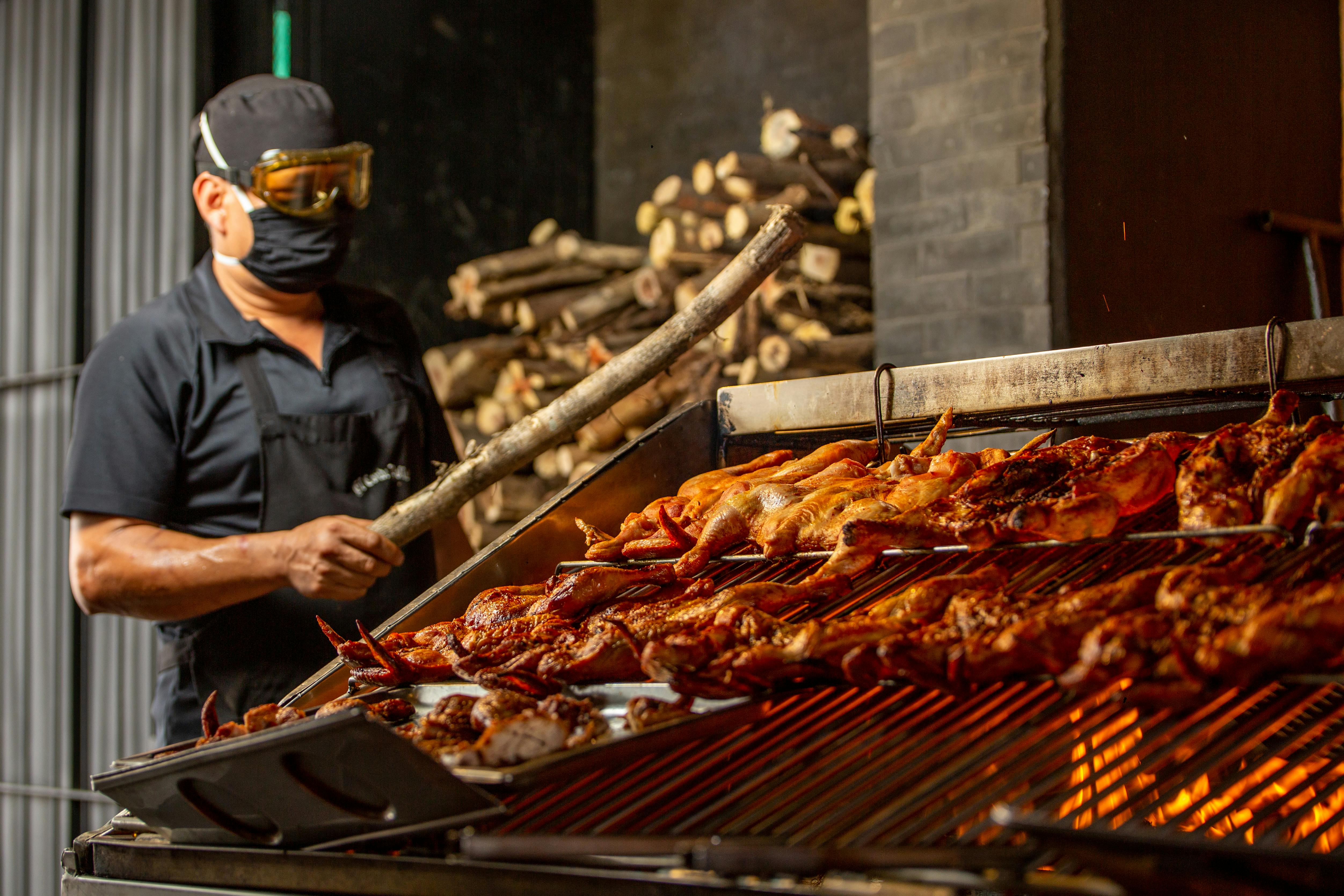 Man Roasting Chicken on a Barbecue · Free Stock Photo
