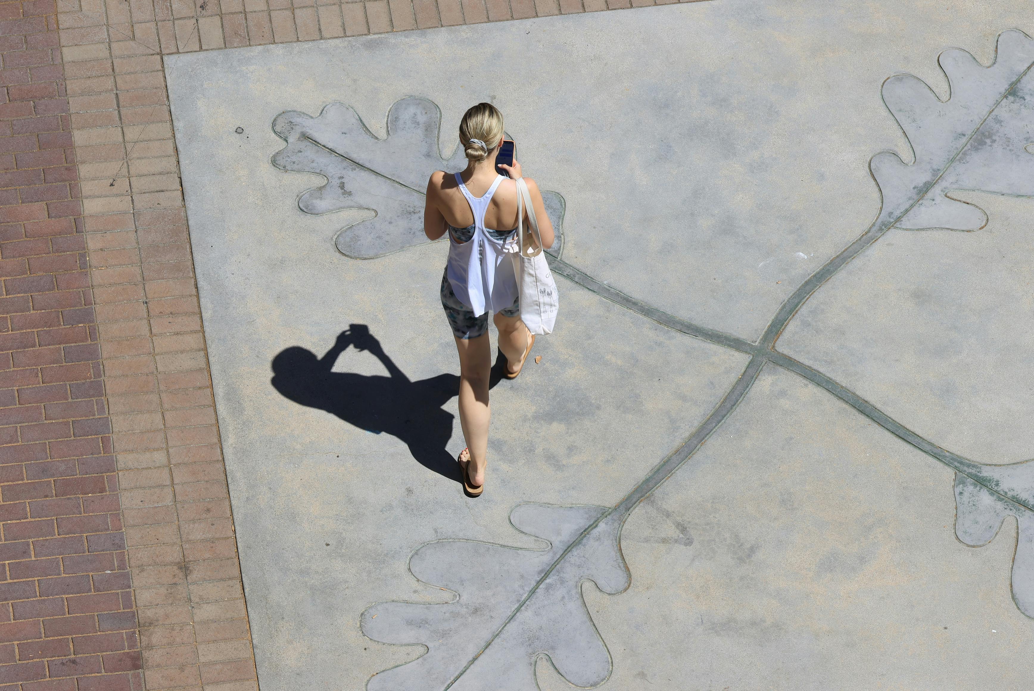 Woman Casting Shadow on Pavement · Free Stock Photo