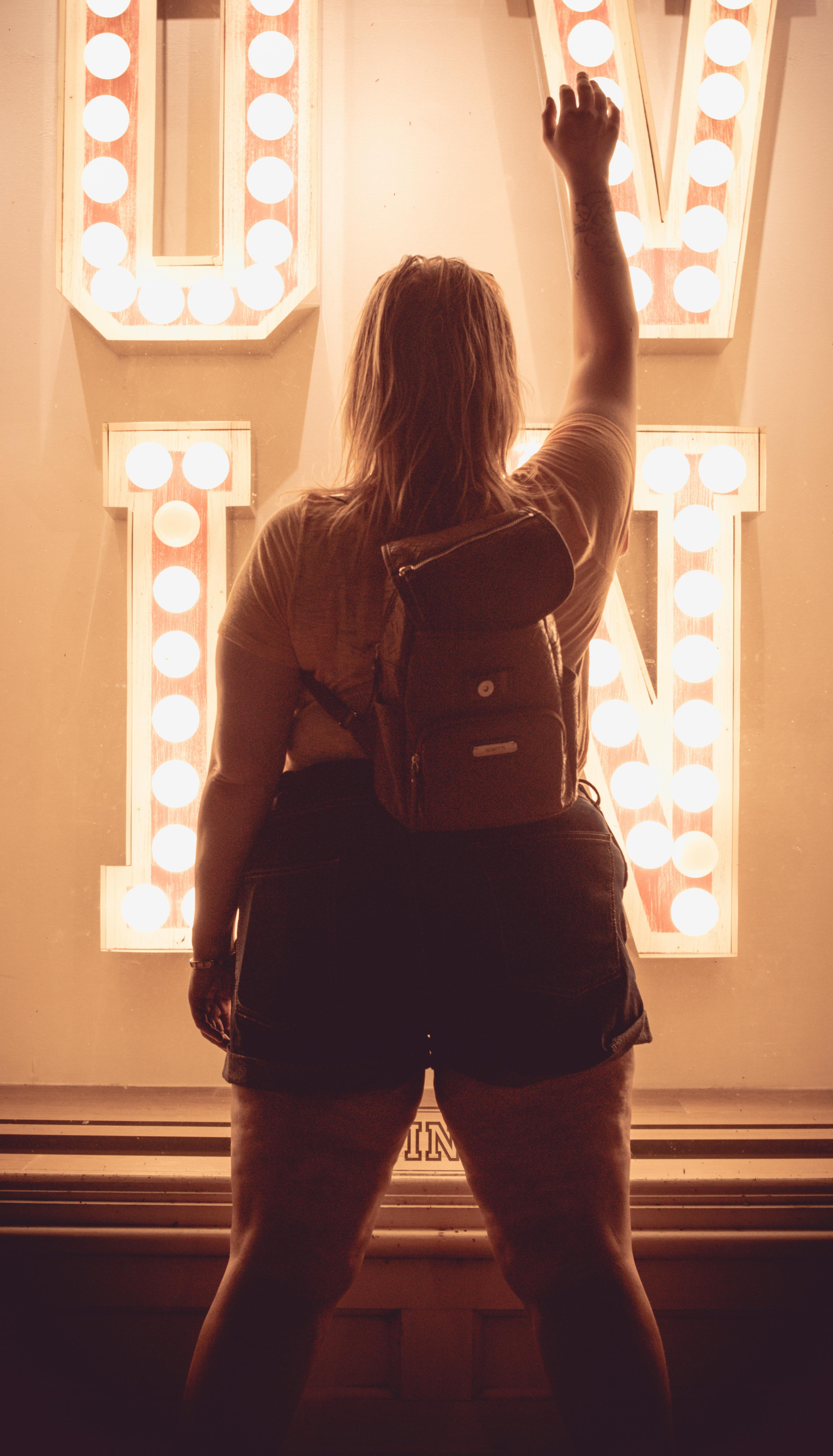 Woman Wearing Backpack Posing by Neon · Free Stock Photo