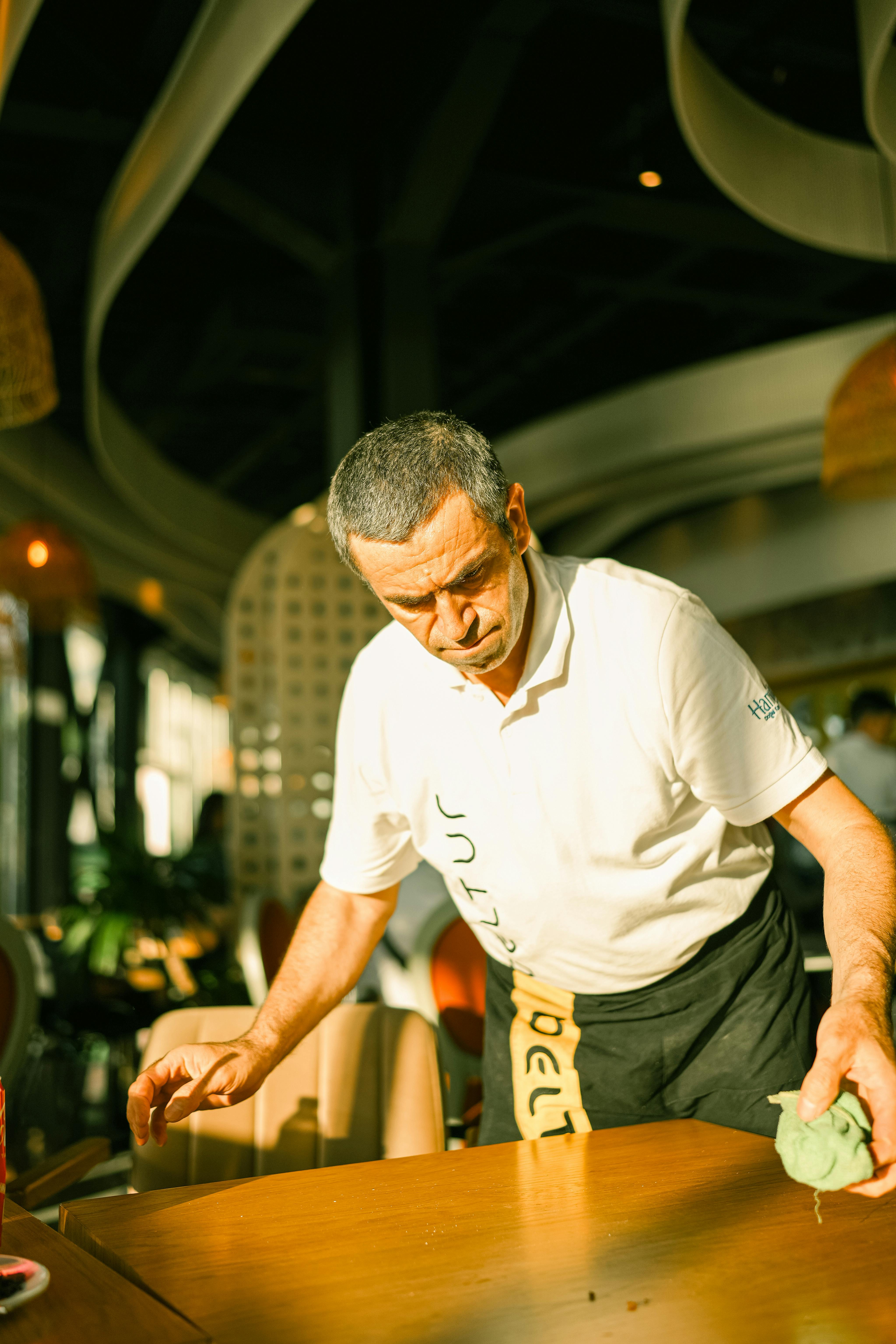 Male employee cleaning floor in restaurant · Free Stock Photo