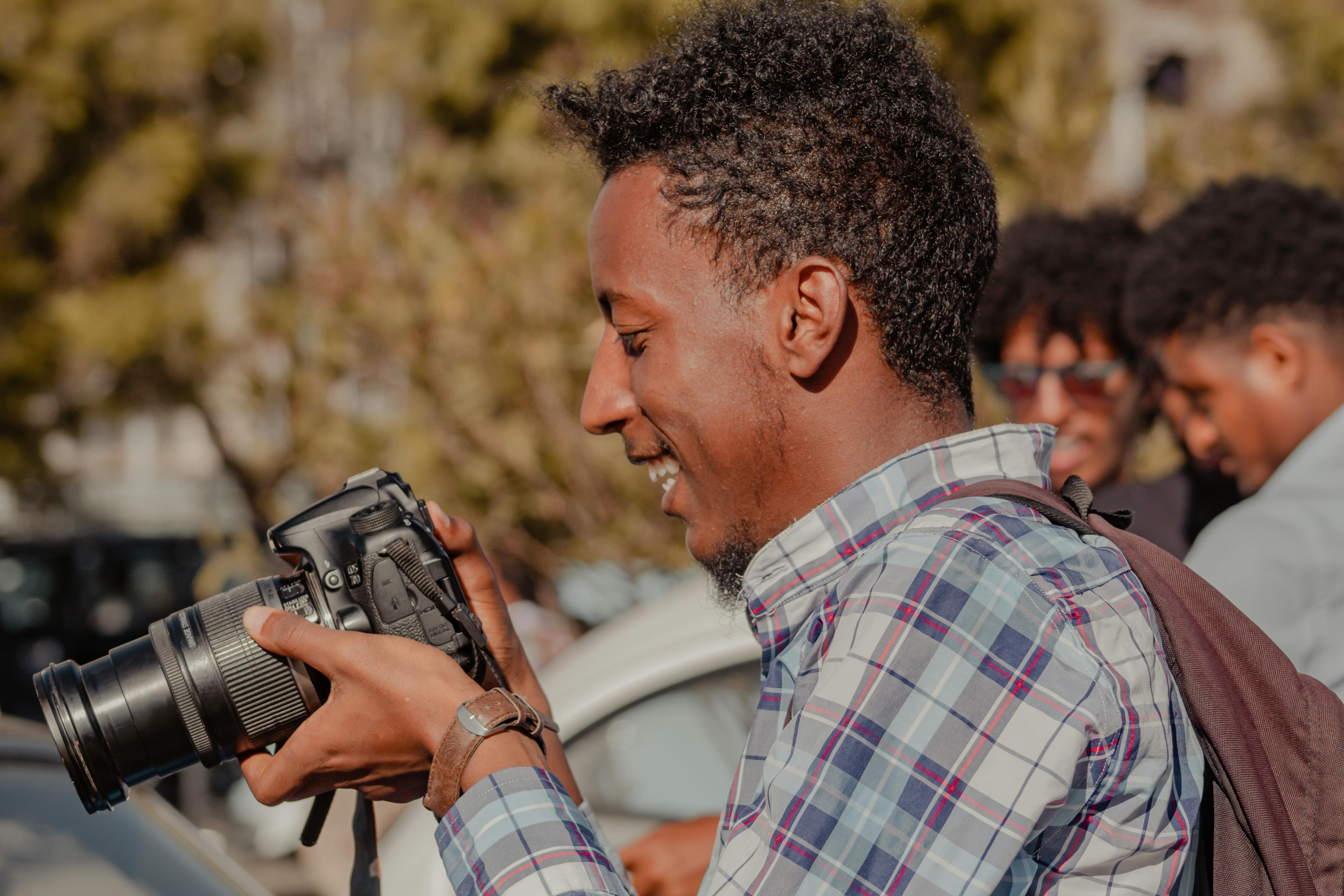 Man Holding Black Dslr Camera · Free Stock Photo