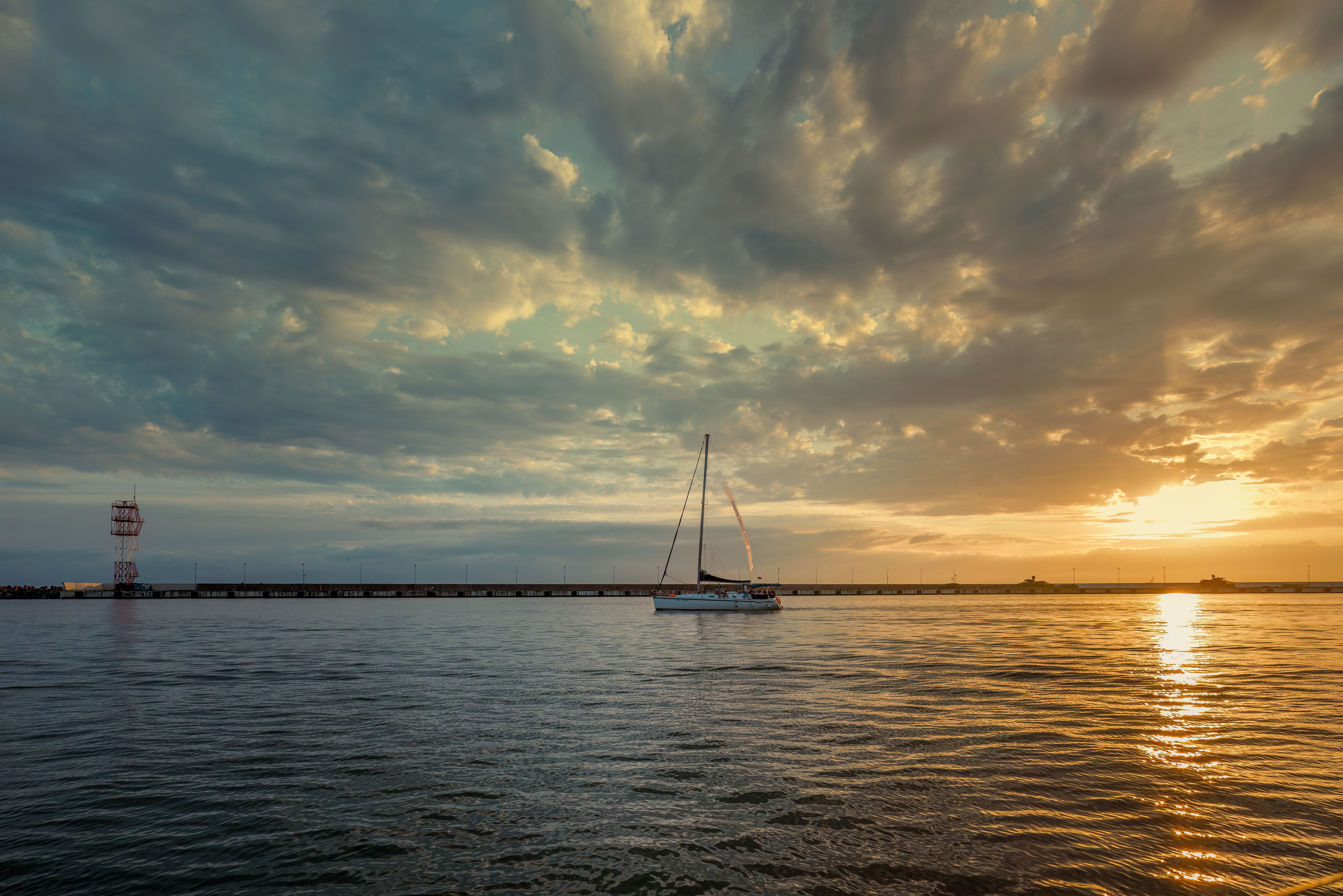 Sailboat on Water near Coast at Sunset · Free Stock Photo