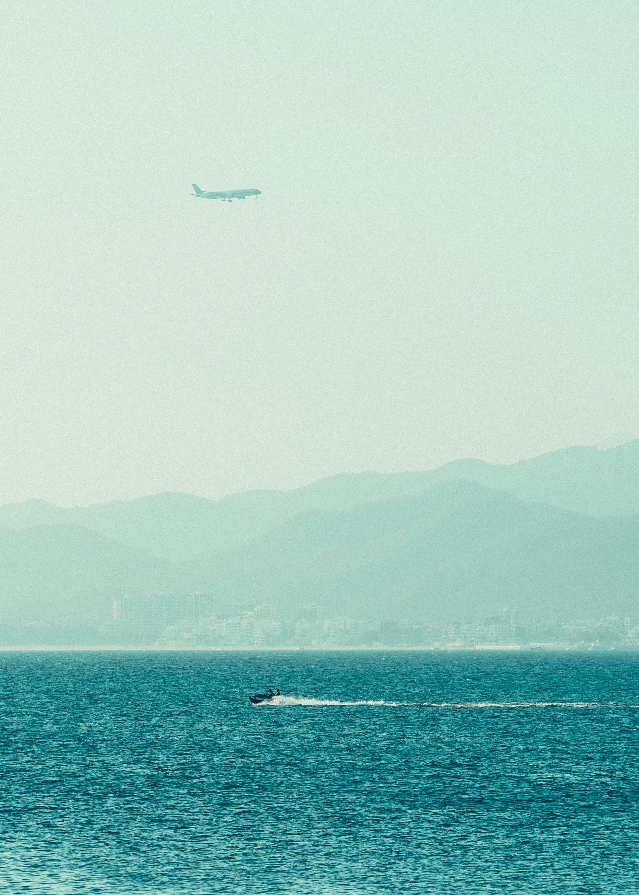 Airplane over Blue Sea · Free Stock Photo