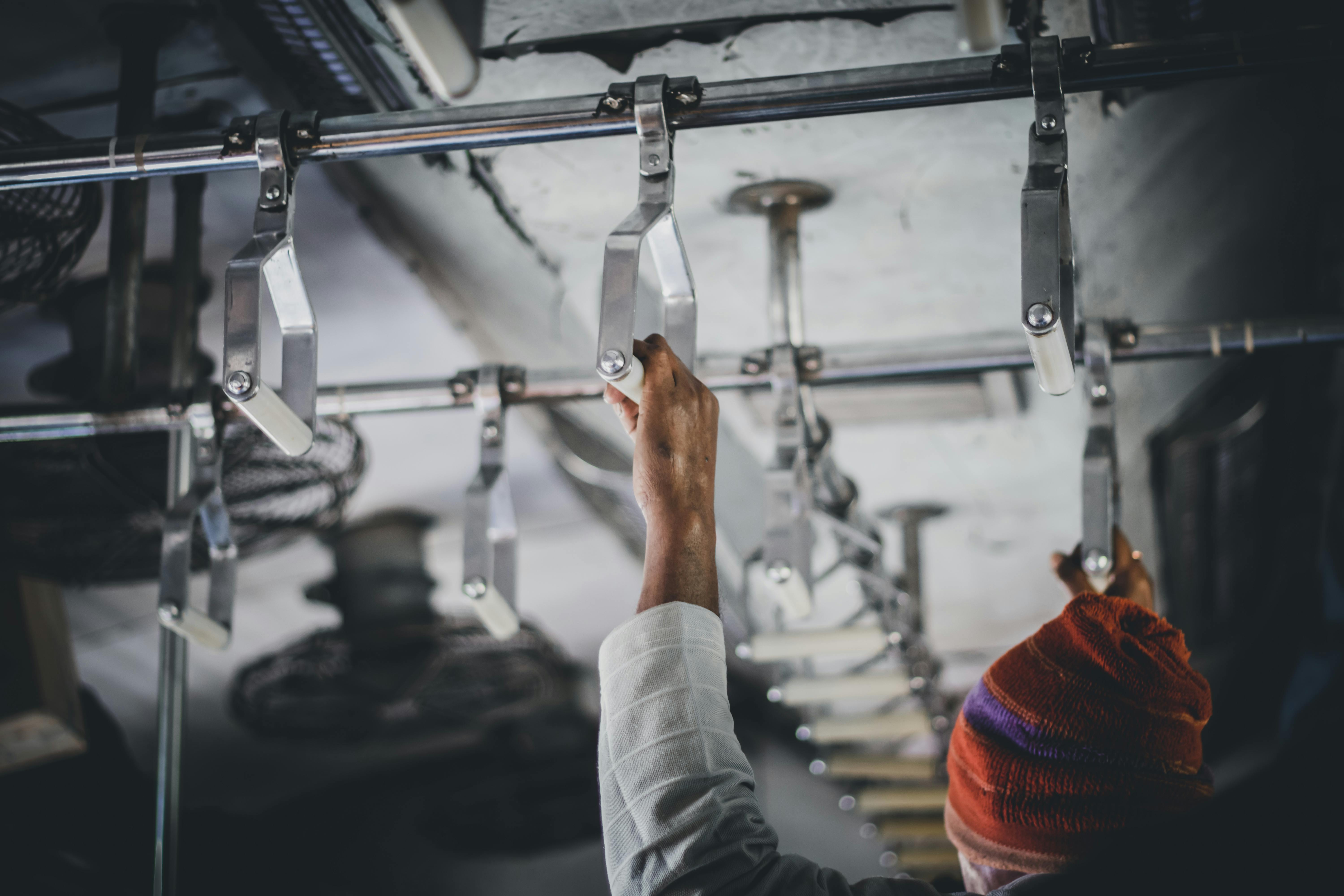 Person Holding on Overhead Handle · Free Stock Photo