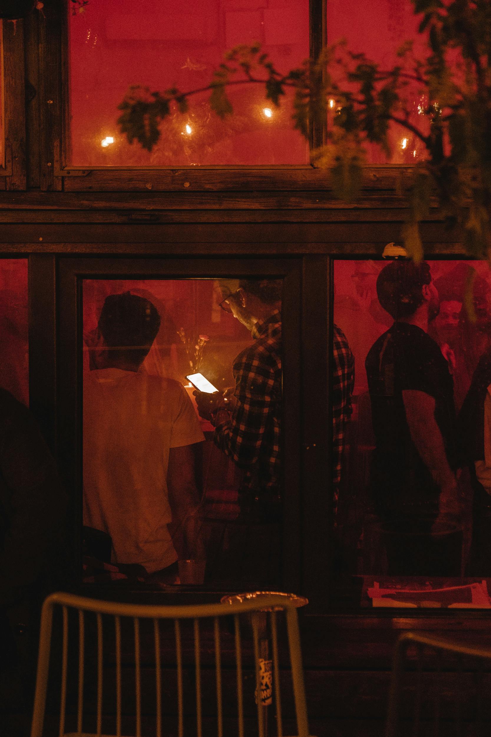 People in Red Light behind Windows · Free Stock Photo