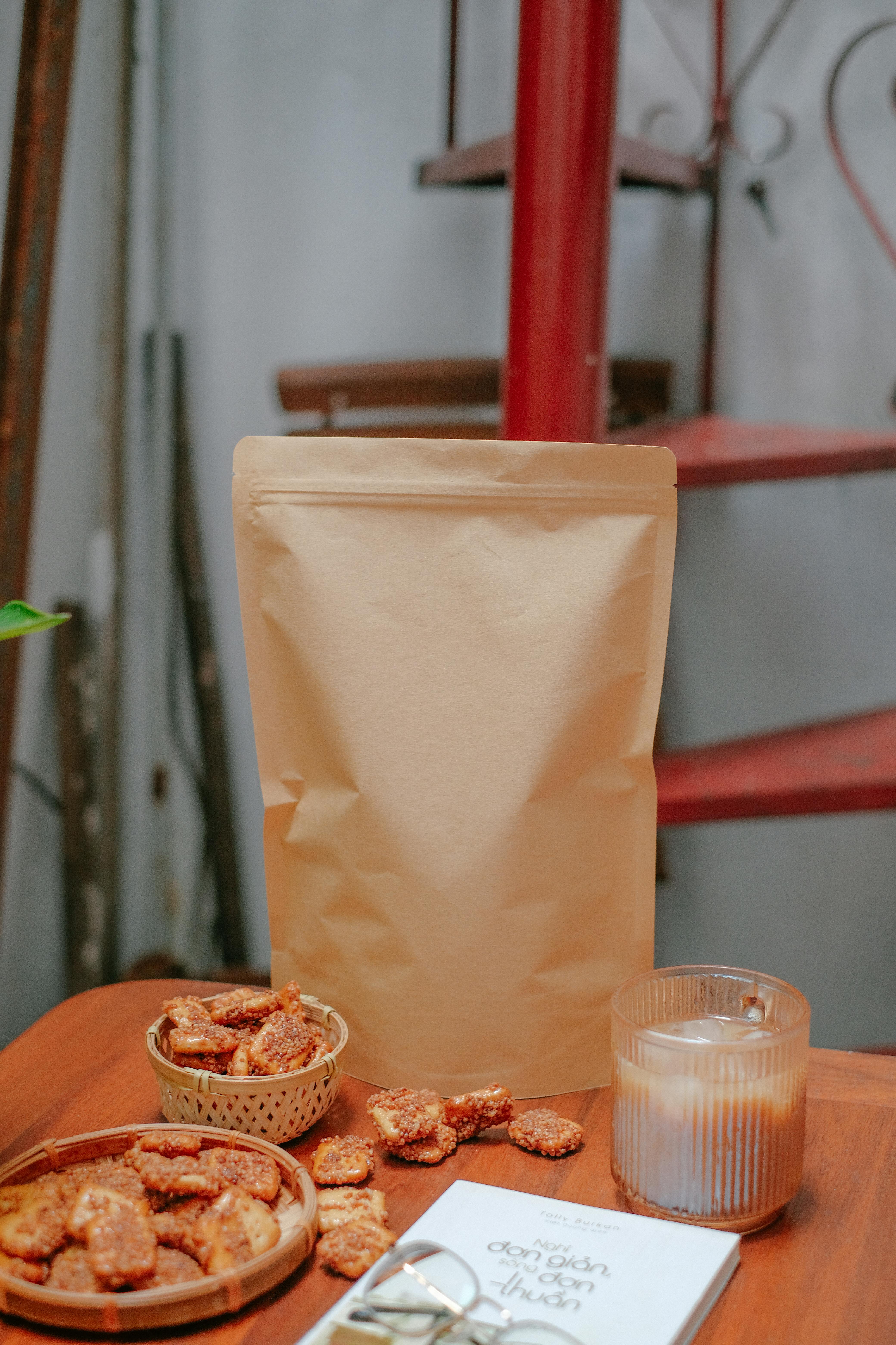 Snacks, Book, Eyeglasses, Packet, Glass on Wooden Table · Free Stock Photo