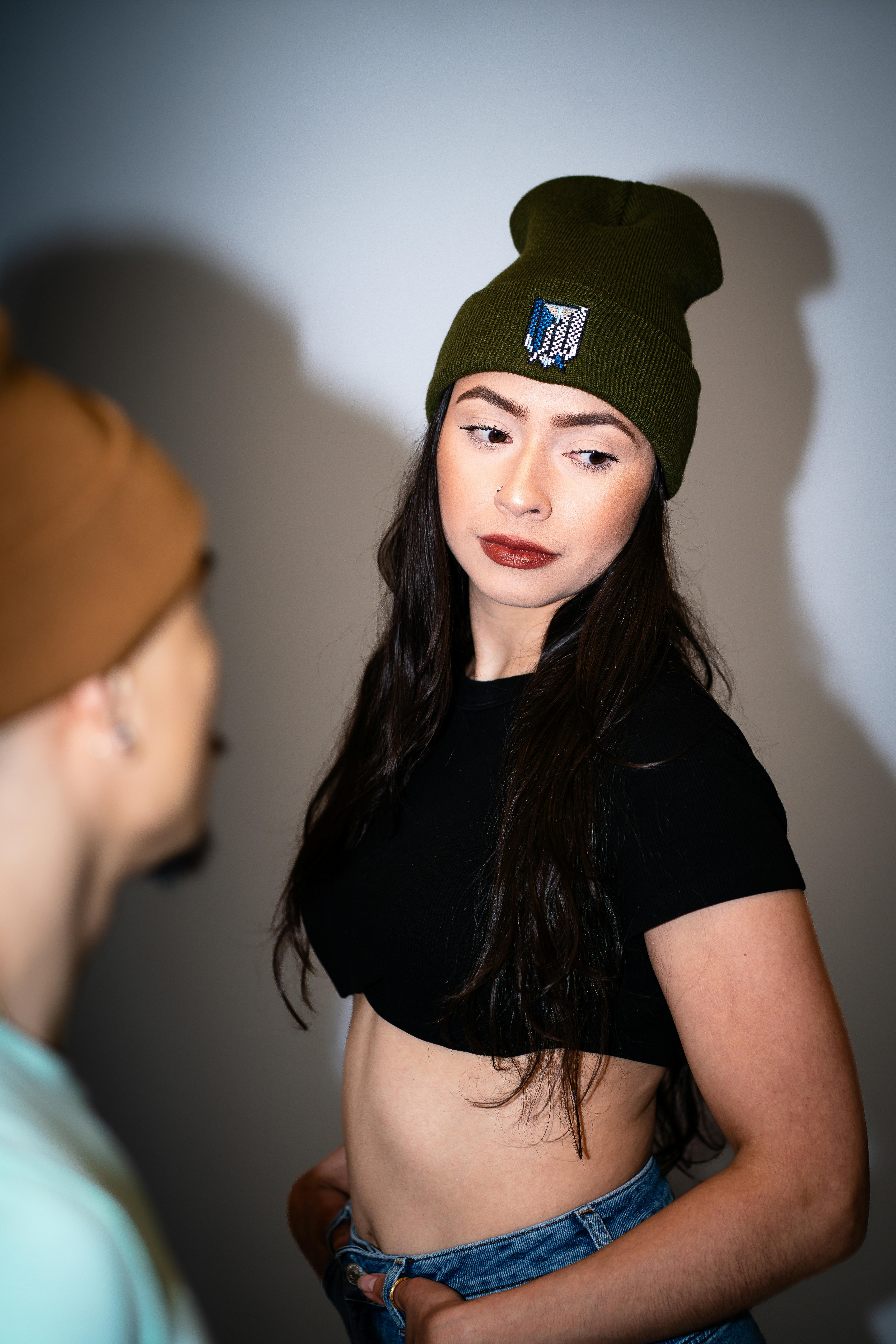 Serious female model in trendy cap in studio · Free Stock Photo