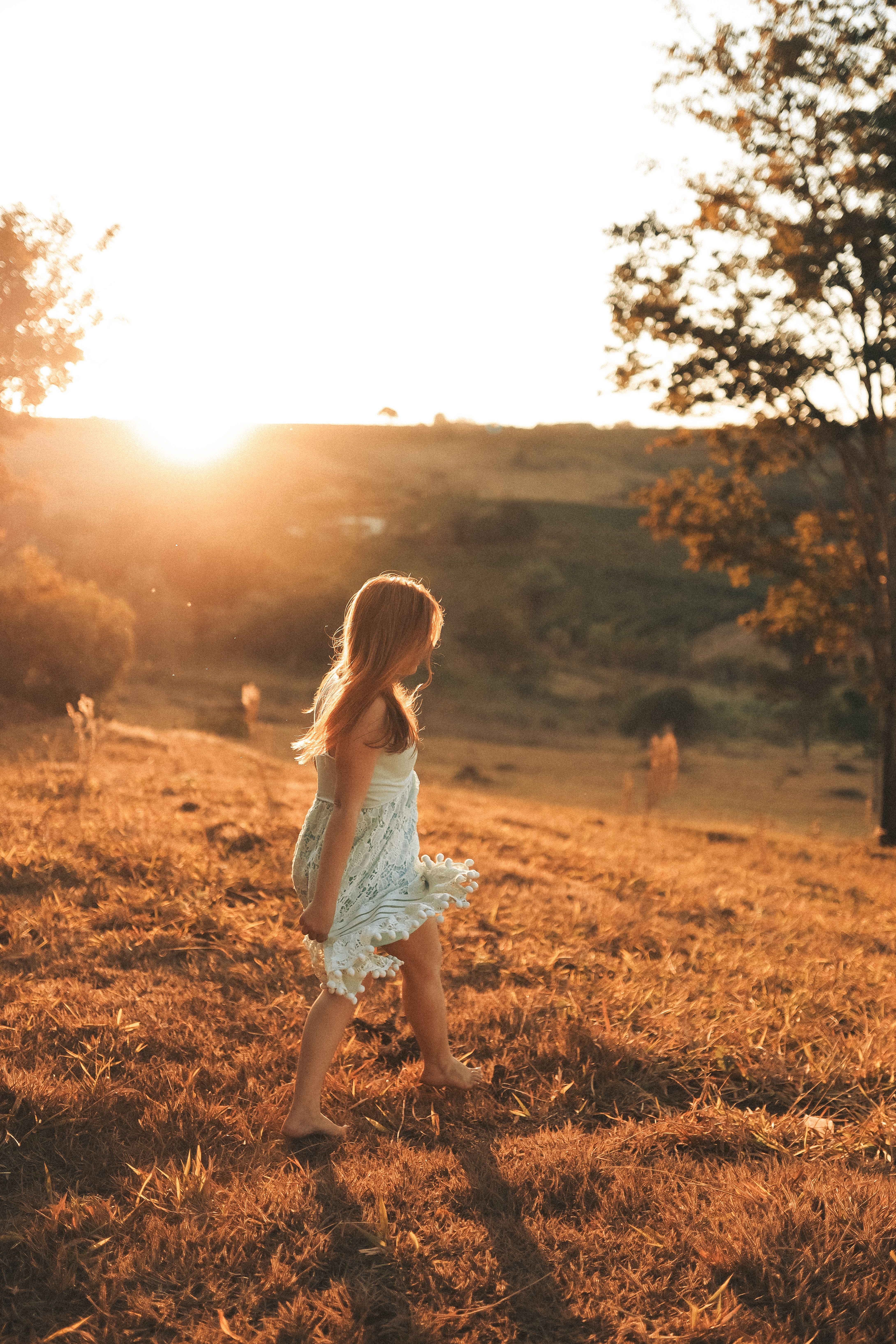 Sun Setting over a Long-Haired Girl Walking on a Countryside Hill ...