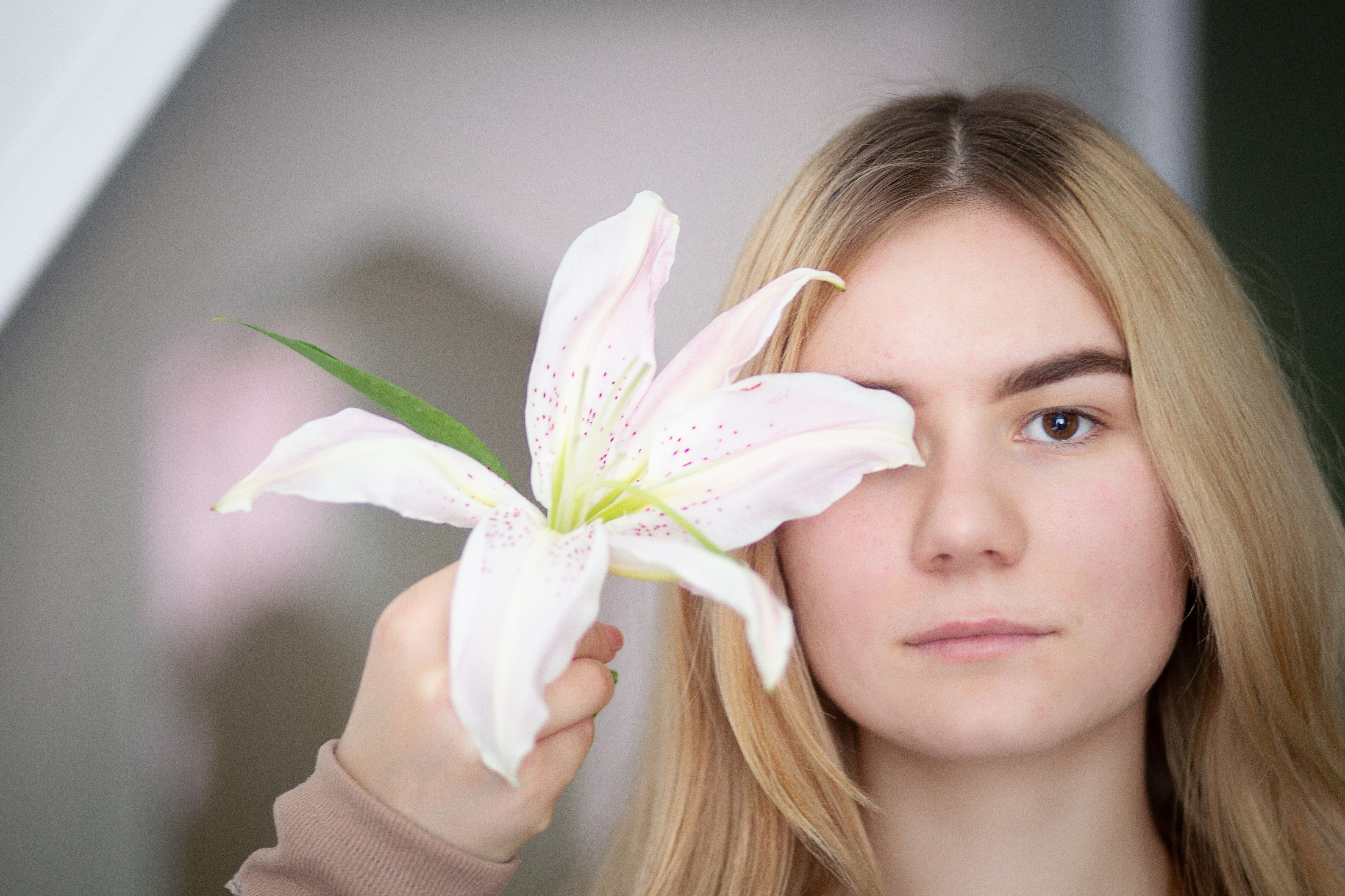 A woman holding a white lily in front of her face · Free Stock Photo