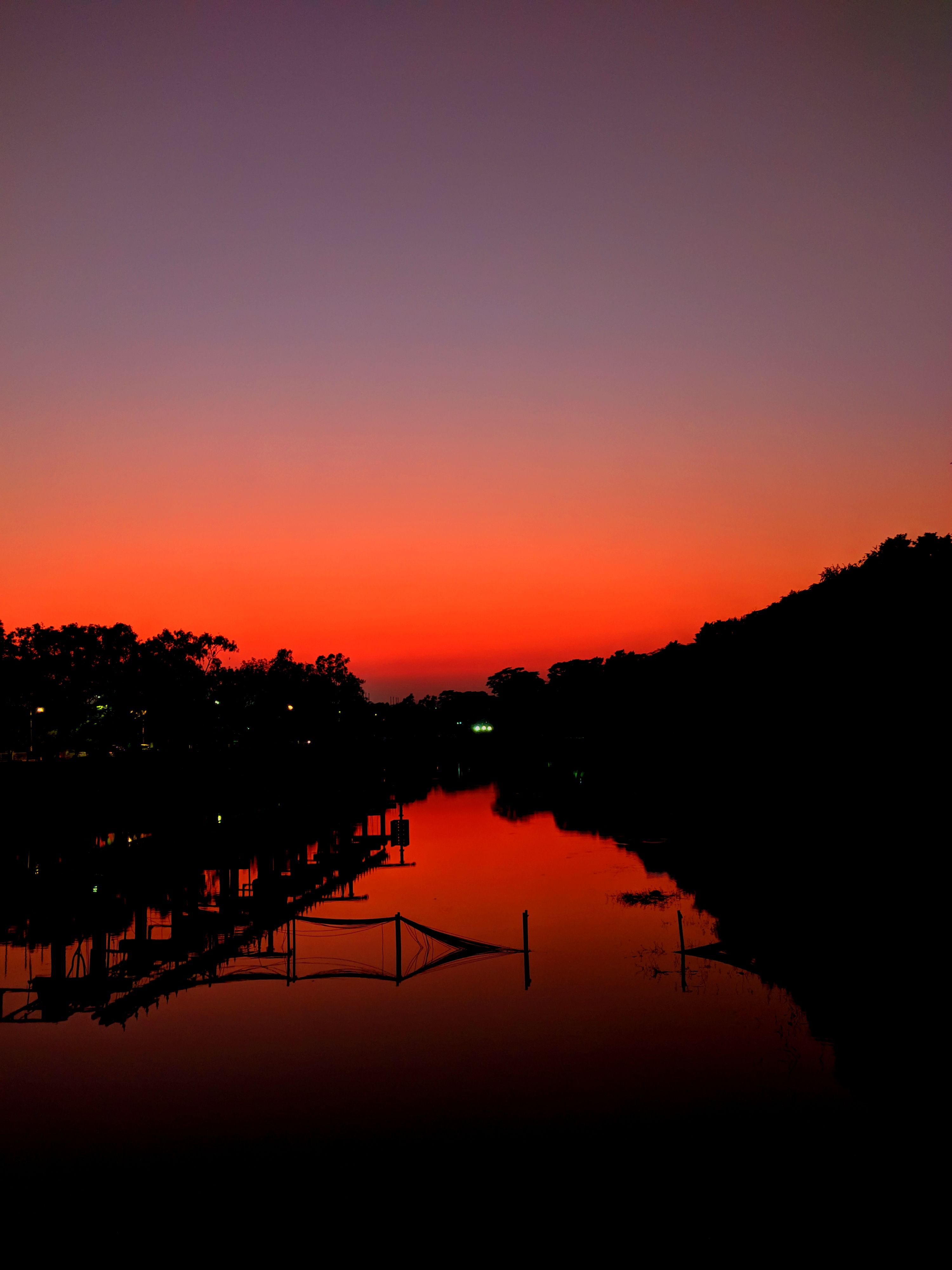 Red, Clear Sky over Water with Town Silhouette behind · Free Stock Photo