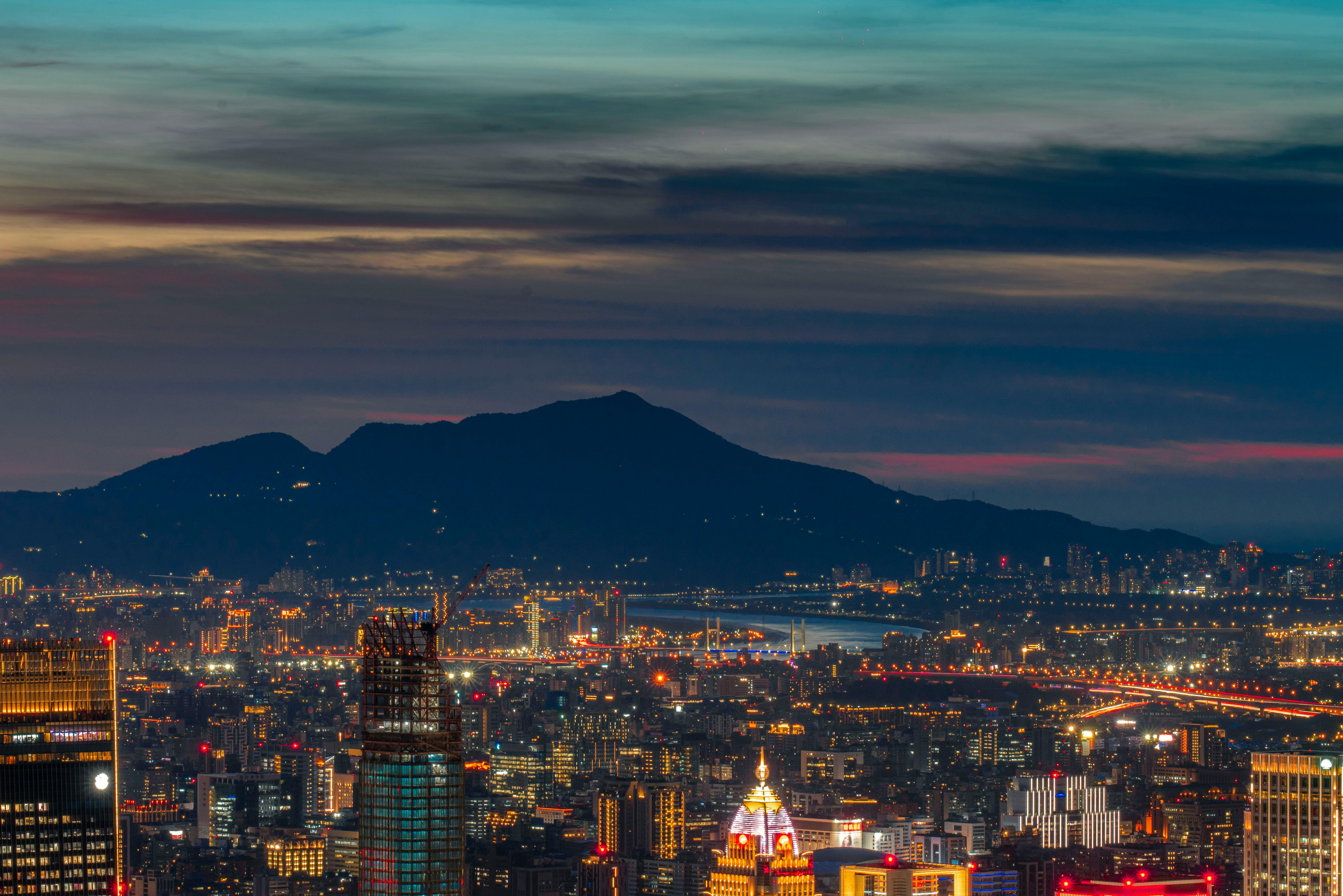 Mountain Towering over Illuminated City · Free Stock Photo