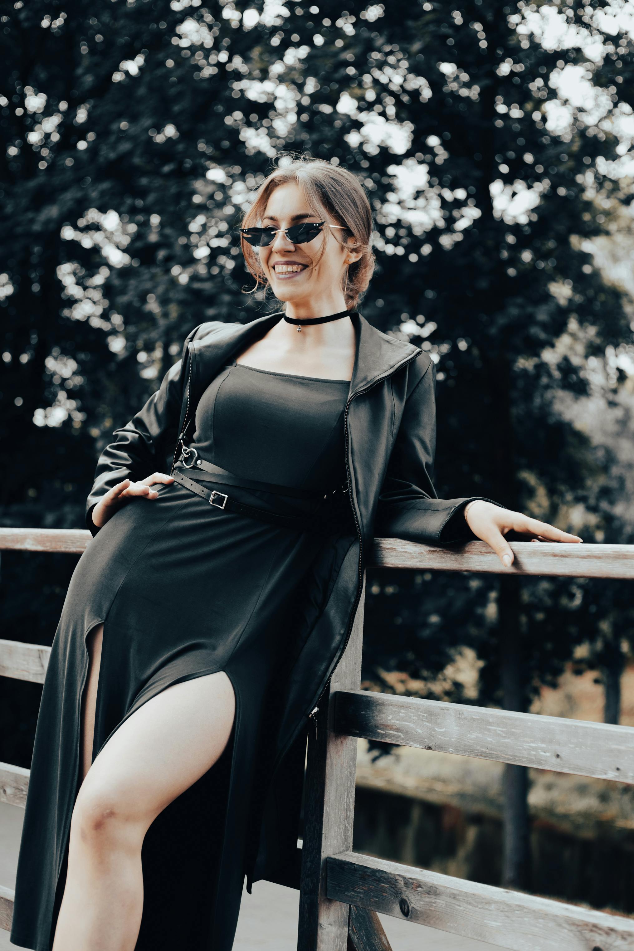 Young Fashionable Woman in a Black Dress and Sunglasses Standing on a ...